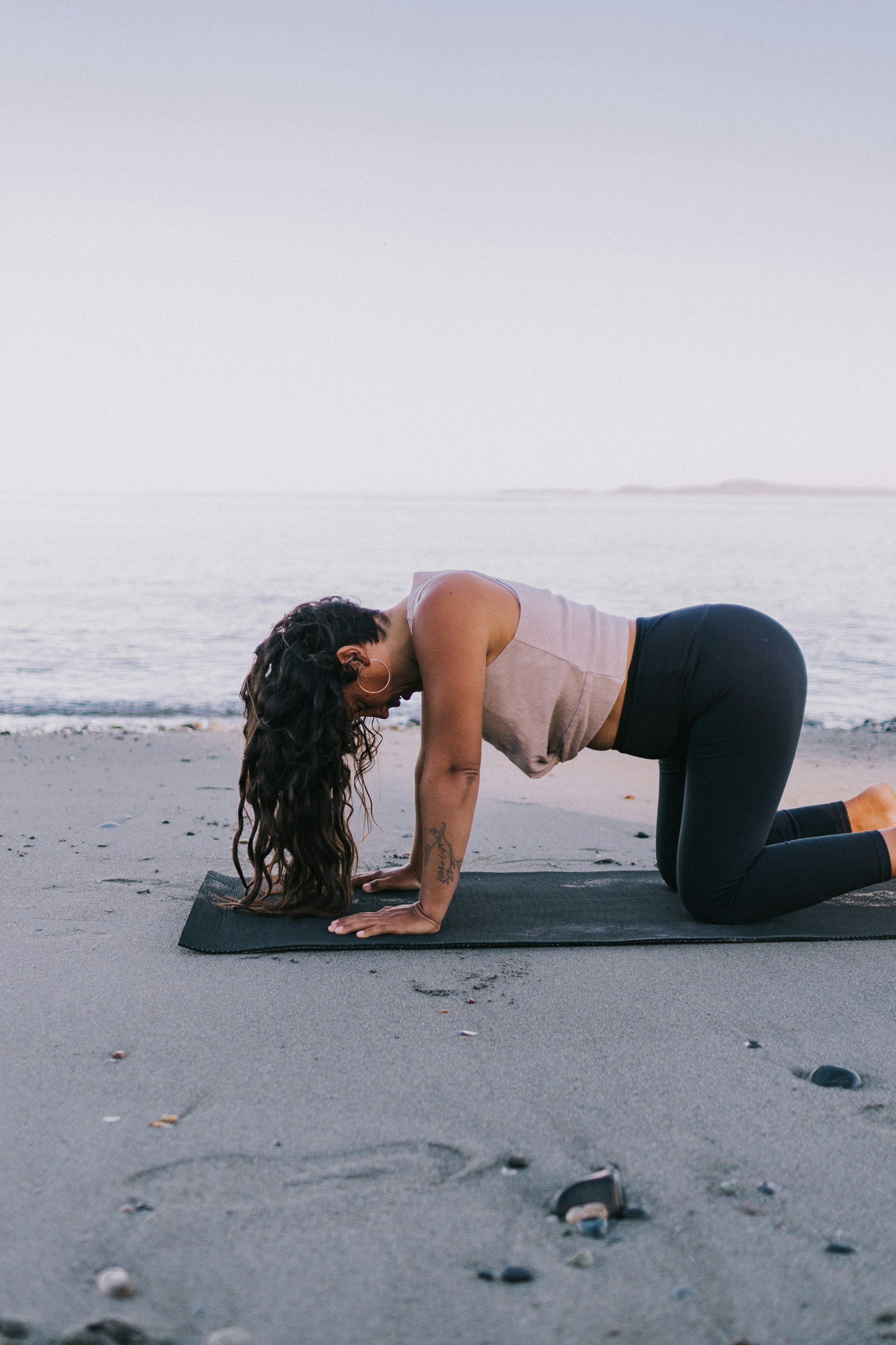 A woman is doing a yoga pose on the beach photo – Free Deception pass ...