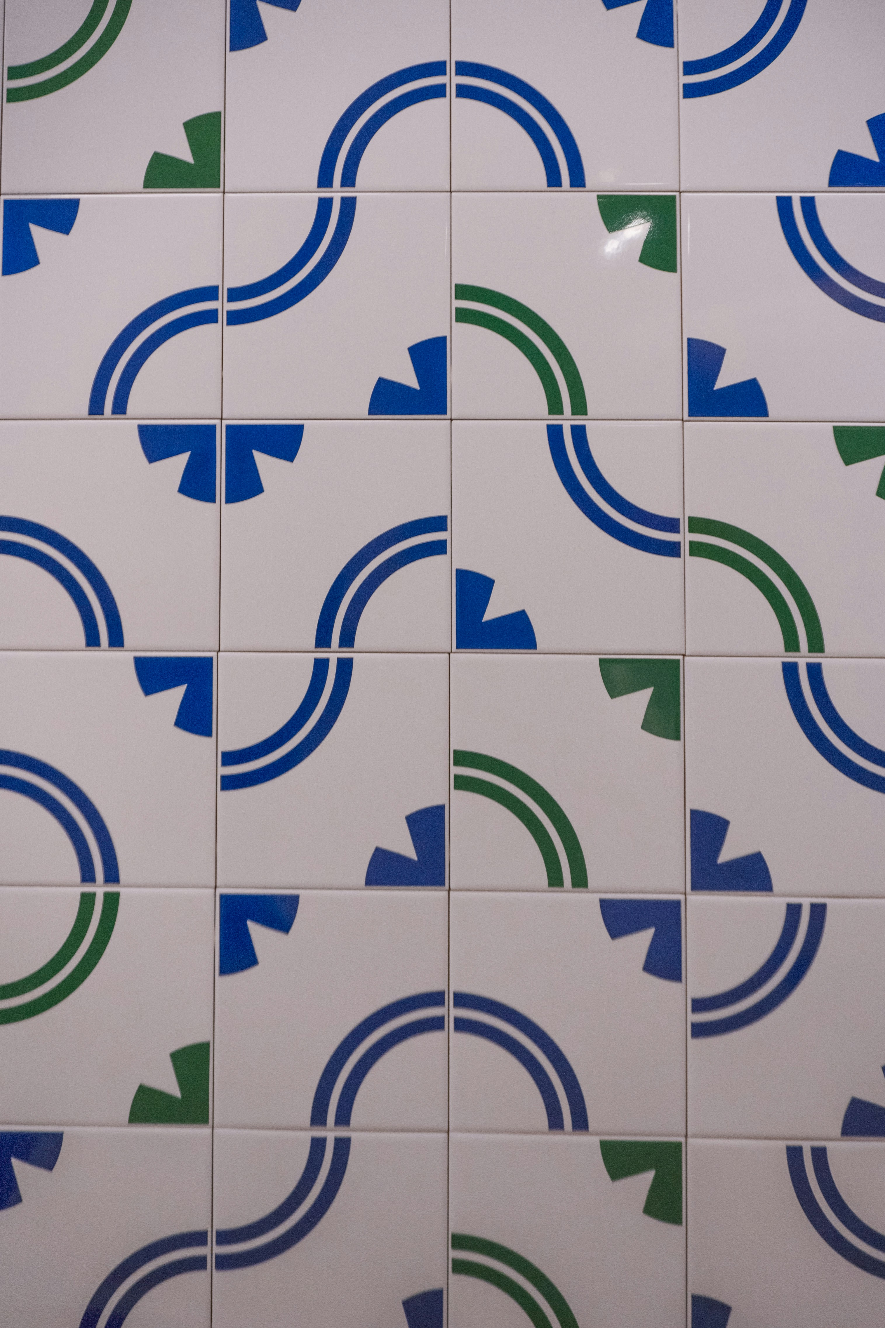 Tile Mosaic Rhythm: Blue Arcs and Green Kicks Across Repeating Tiles