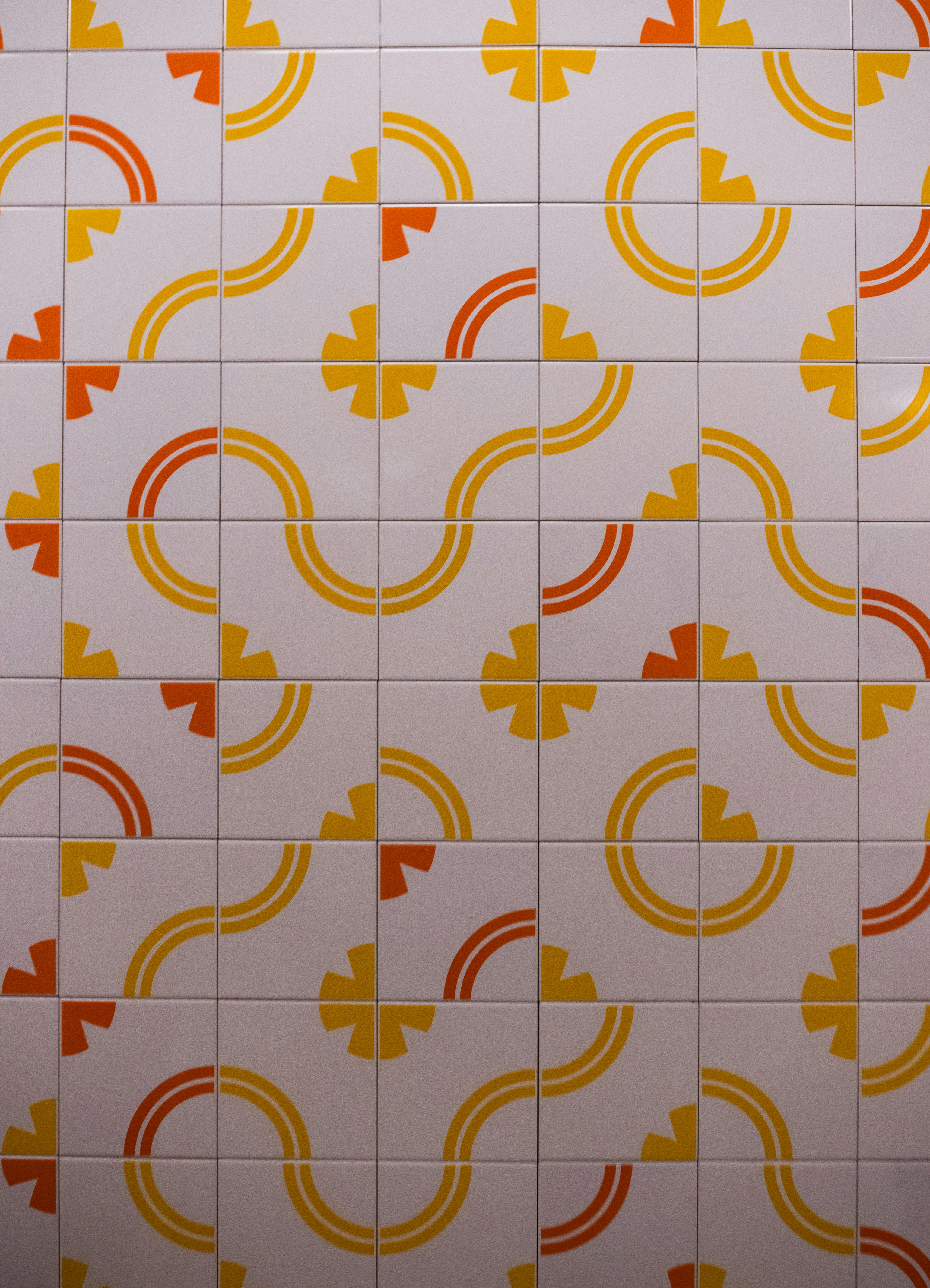Arc-Pattern Mosaic: A Grid of Sunlit Arcs and Arrow Motifs