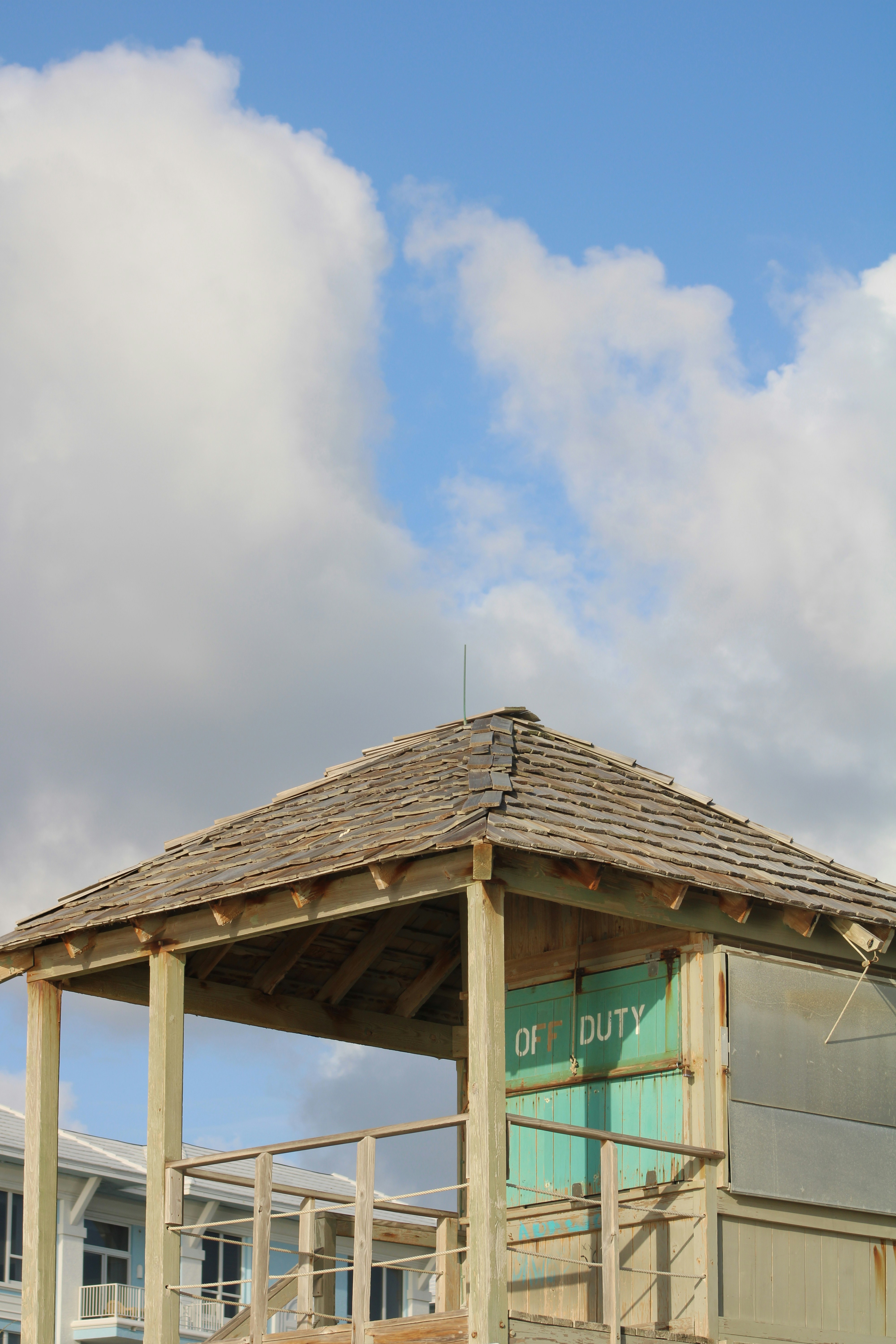 Off Duty Pavilion: Weathered Roofs and a Turquoise Panel Under an Open Sky