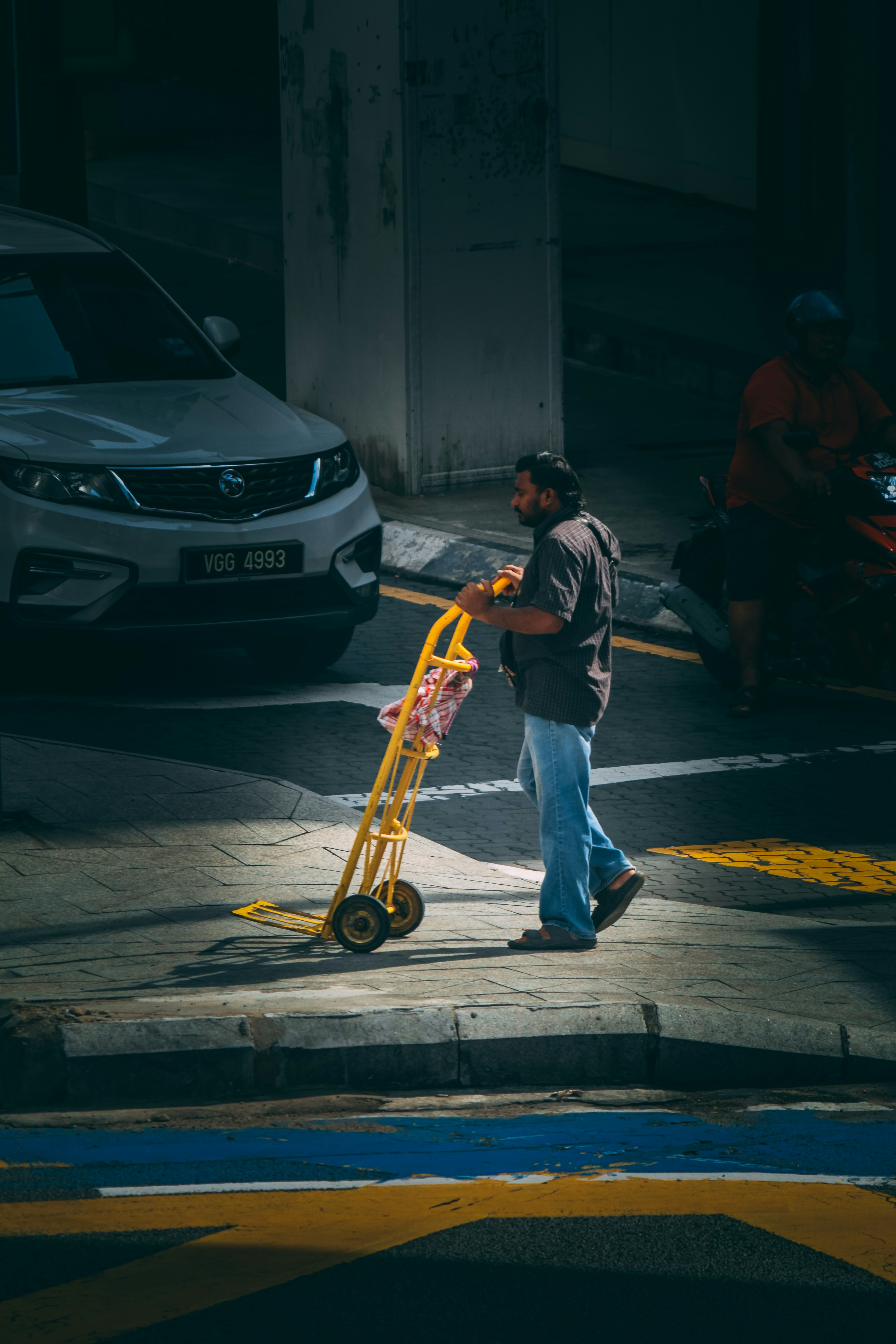 Urban Cargo in the Spotlight: A Man and the Yellow Dolly