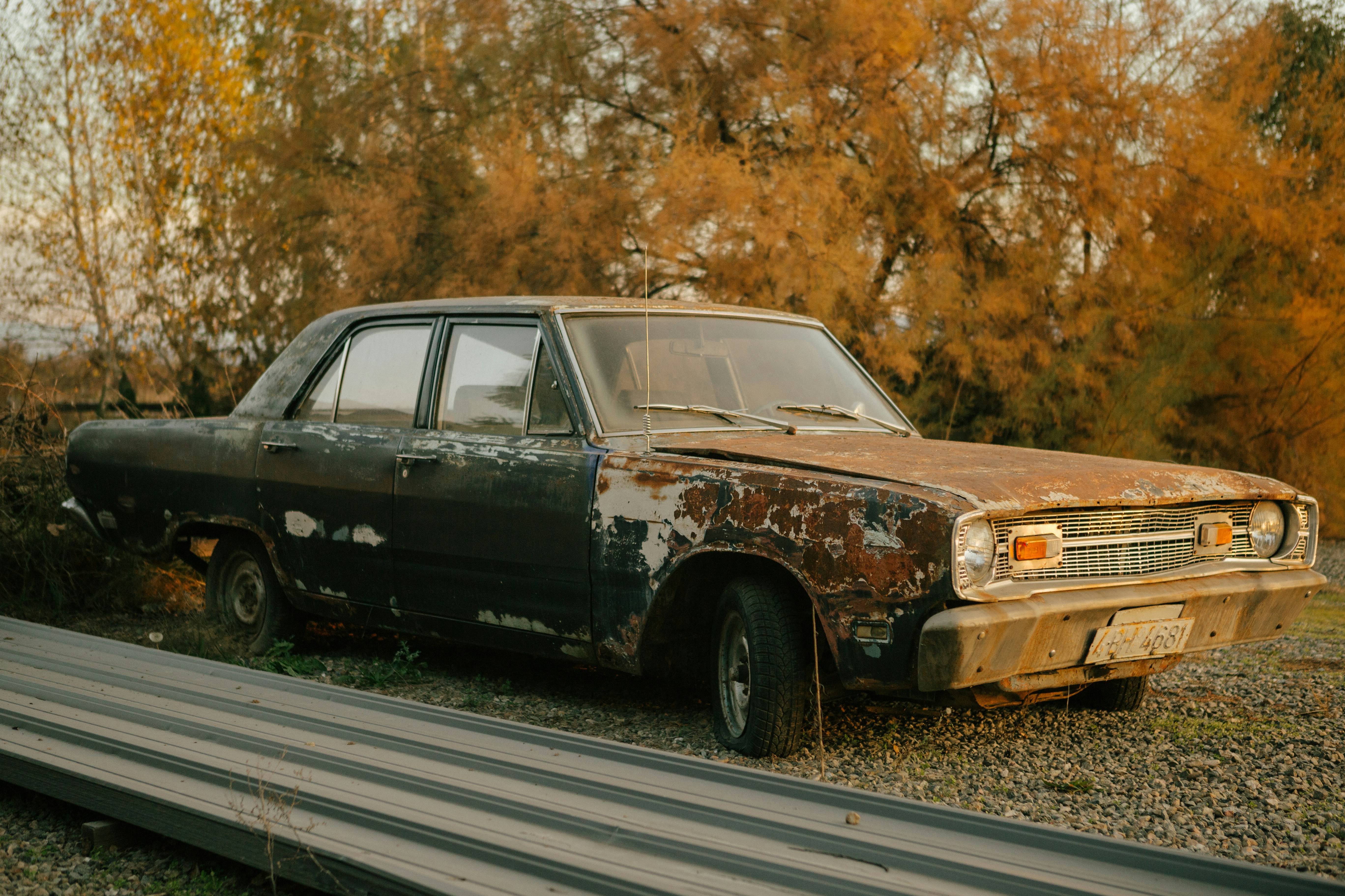 A rusted out car sitting on the side of a road photo – Free Romania ...