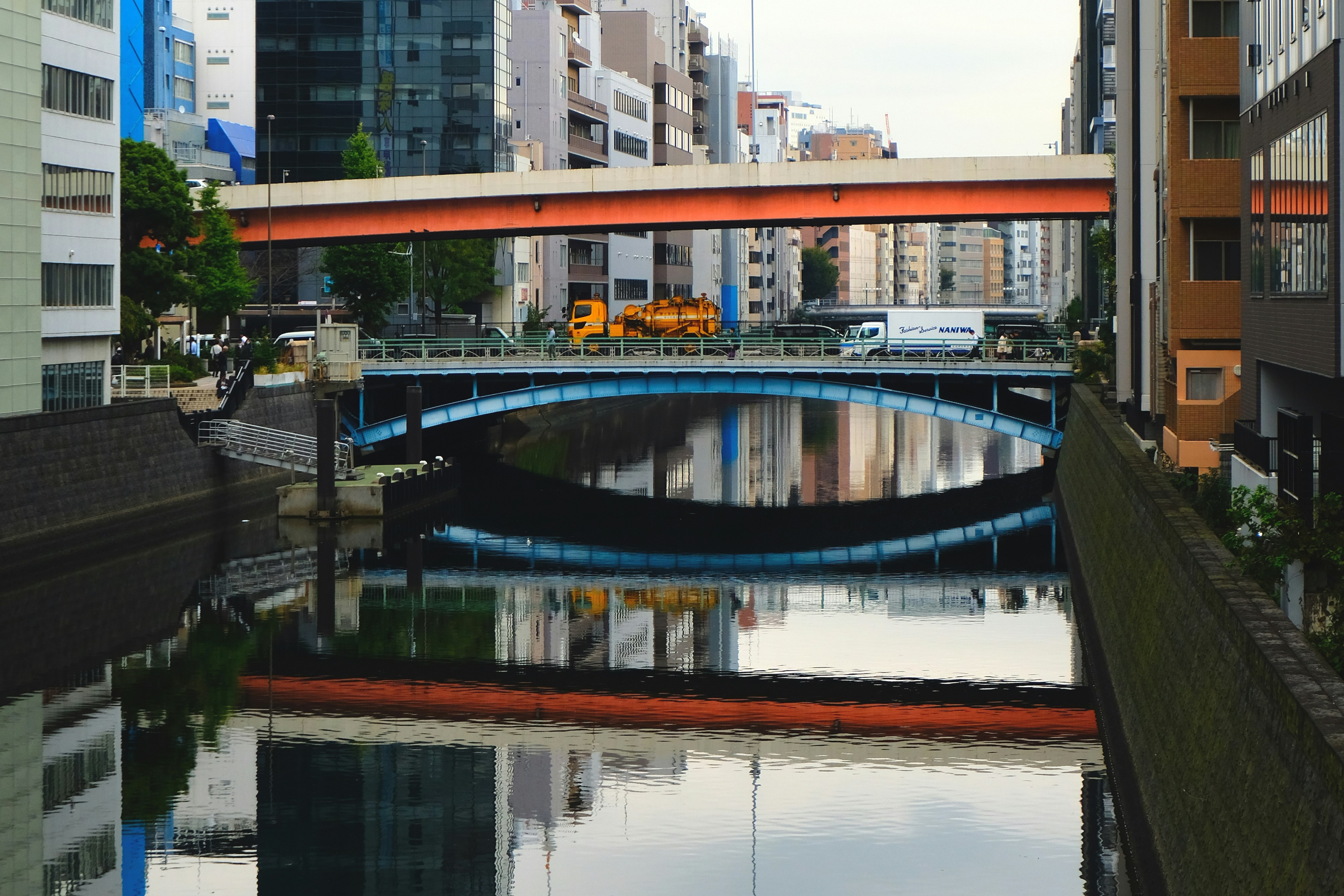 Crimson and Azure Bridges Over a Quiet City Canal