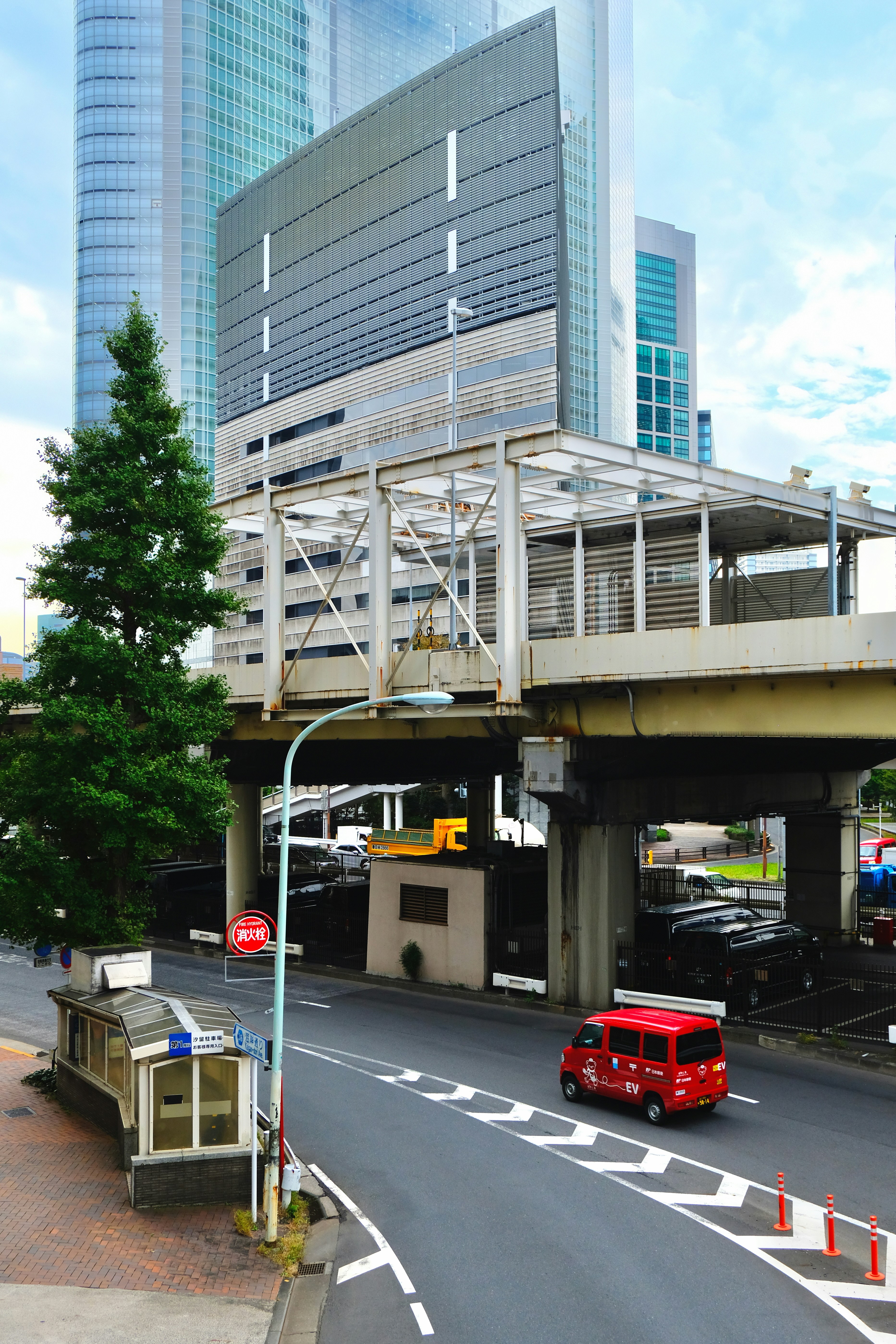 Under the Steel Canopy: A Red Van Navigates a Layered Cityscape