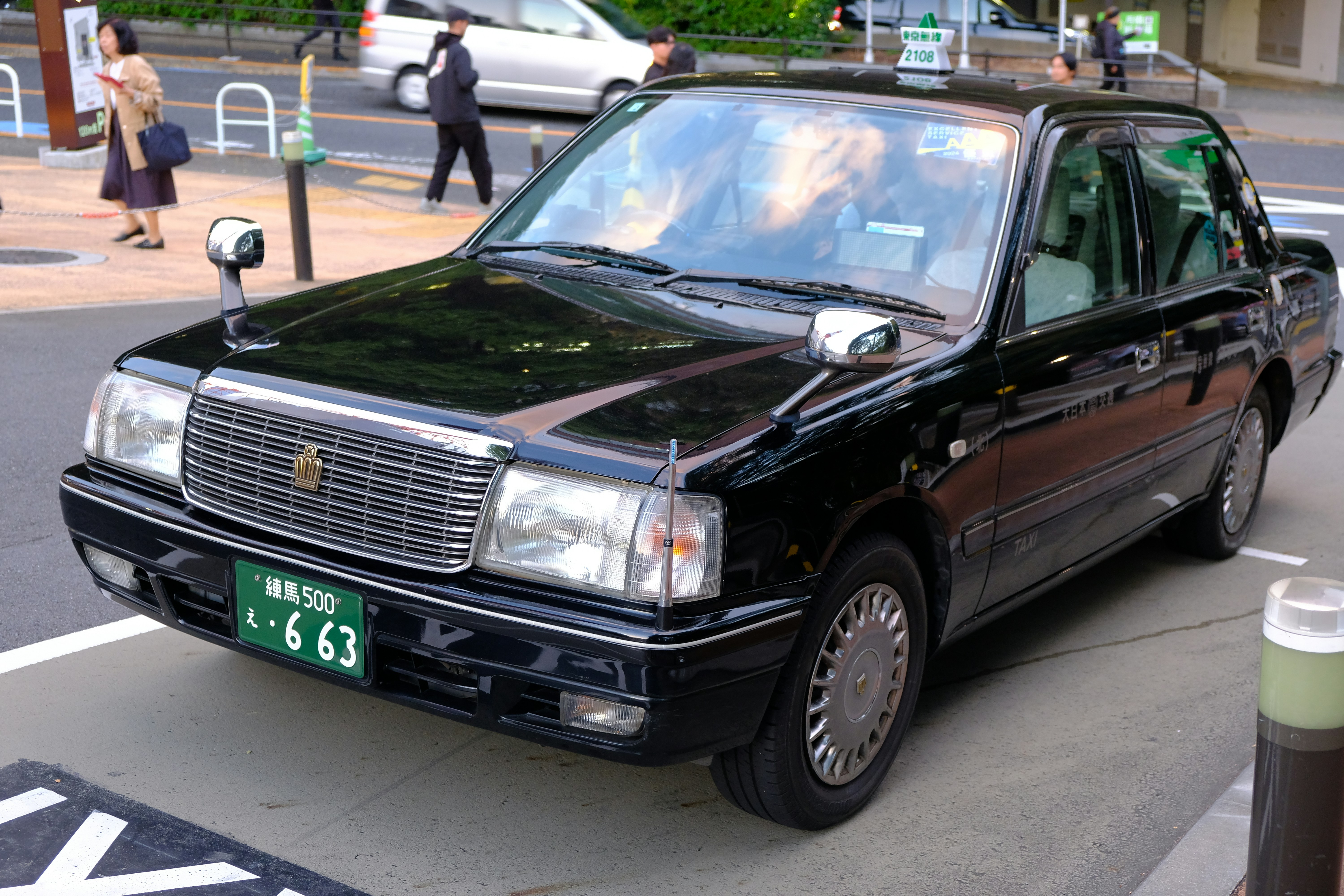 Glinting Contour: A Black Japanese Taxi Rests on a City Street
