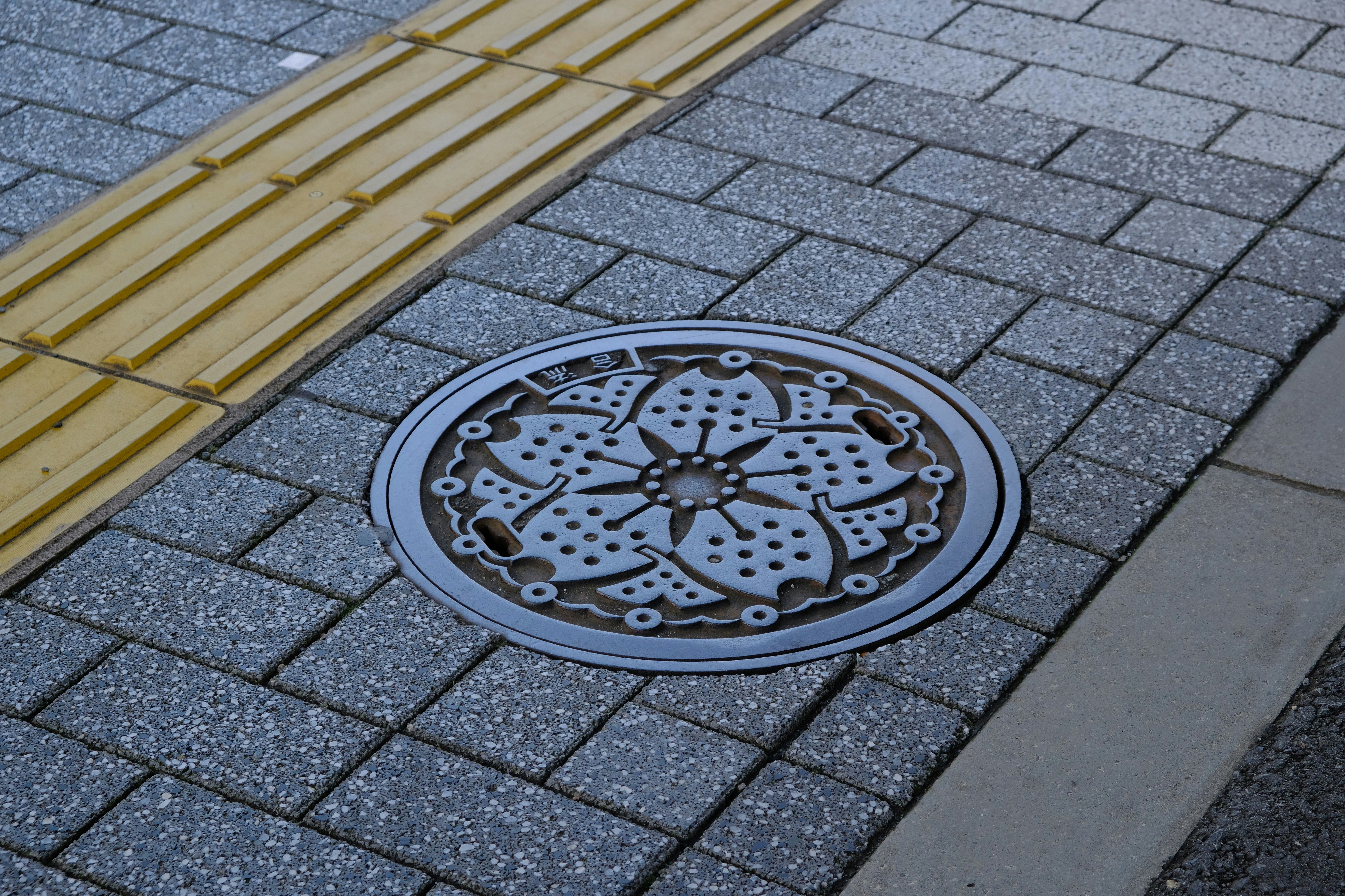 Petaled Pattern in Metal: Urban Mosaic Under Yellow Lines