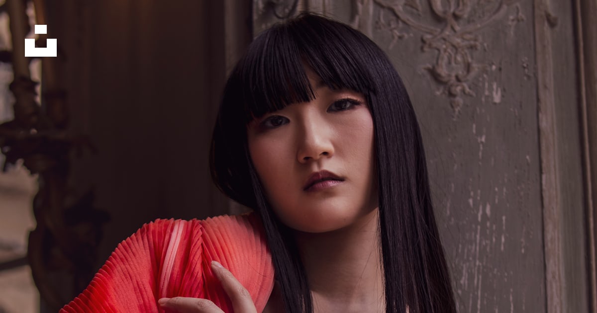 검은 긴 머리를 한 여자가 빨간 물건을 들고 있다 사진 Unsplash의 무료 스타일 이미지