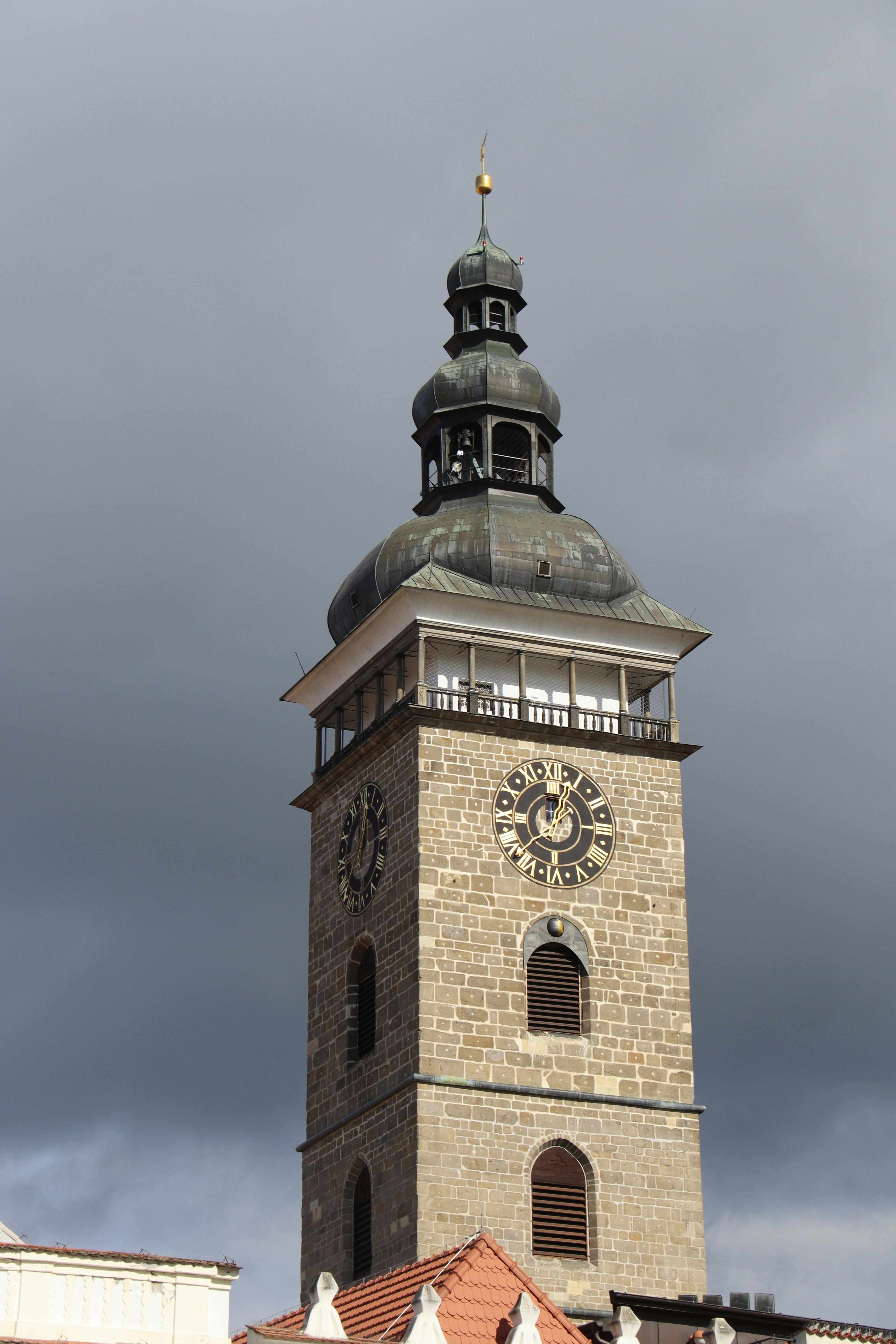 Verdigris Spire: A Stone Clocktower Beneath a Brooding Sky