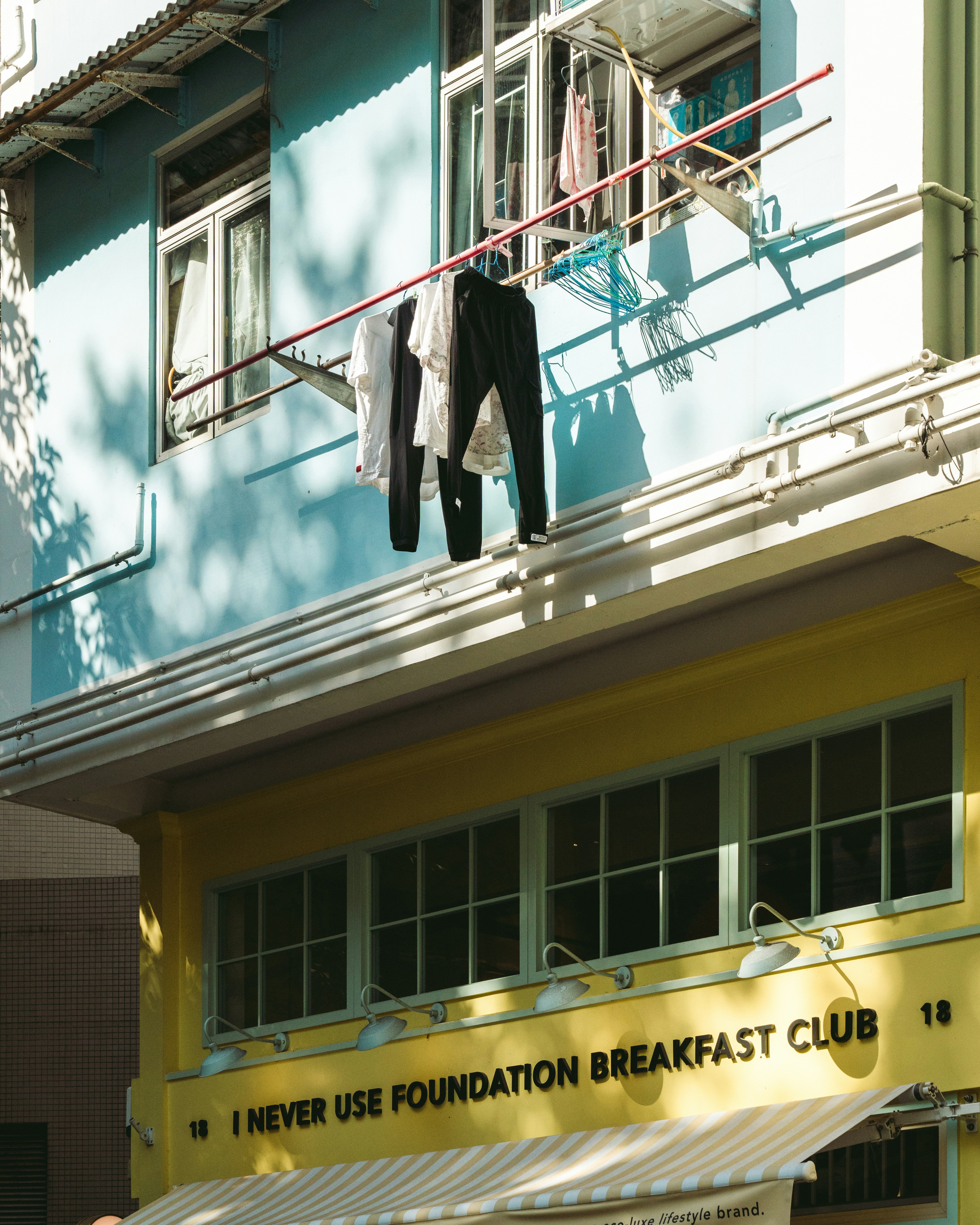 A blue and yellow building with clothes hanging out to dry photo – Free ...