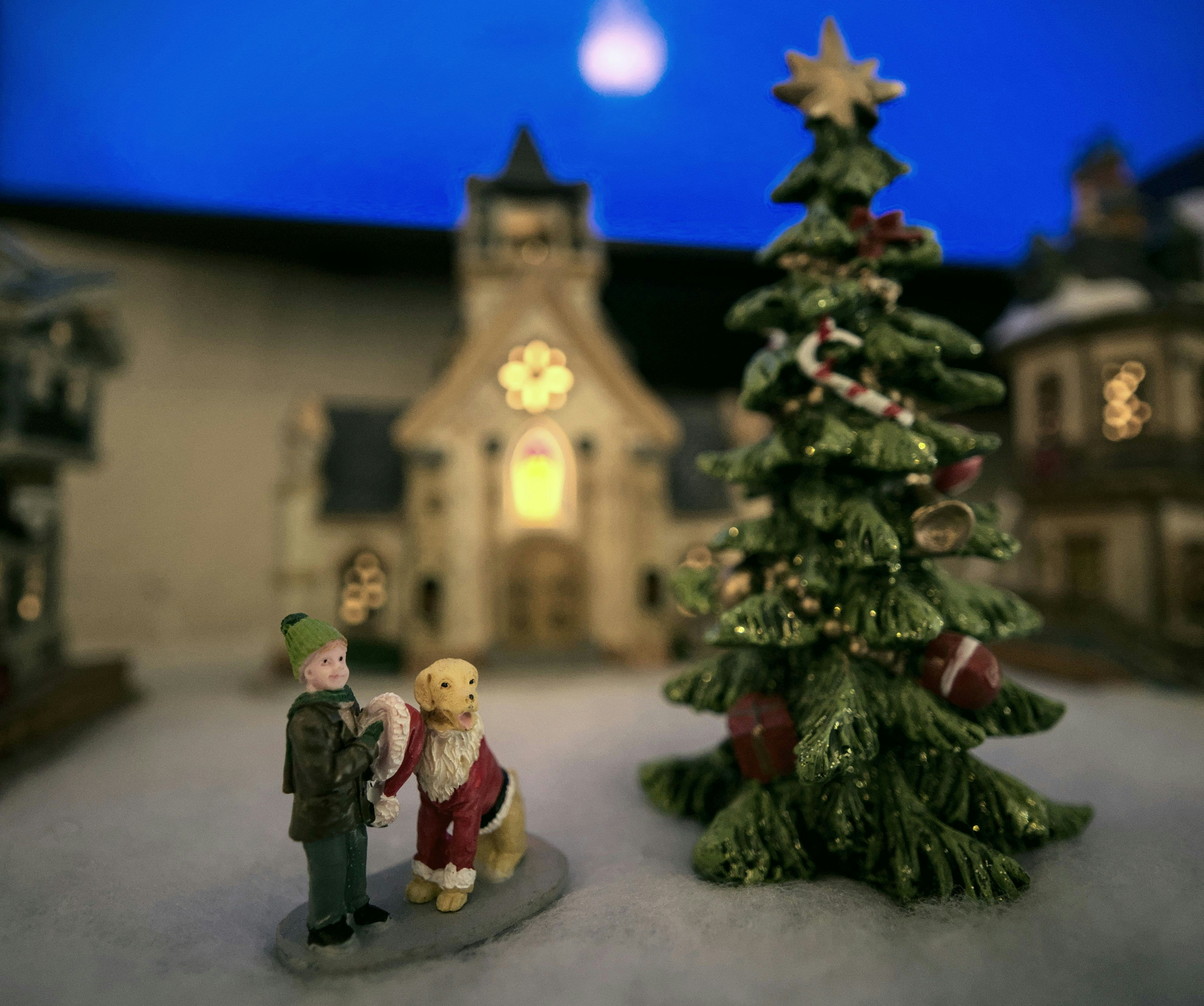 Noel in Soft Focus: Two Figurines Guard a Snowy Miniature Village