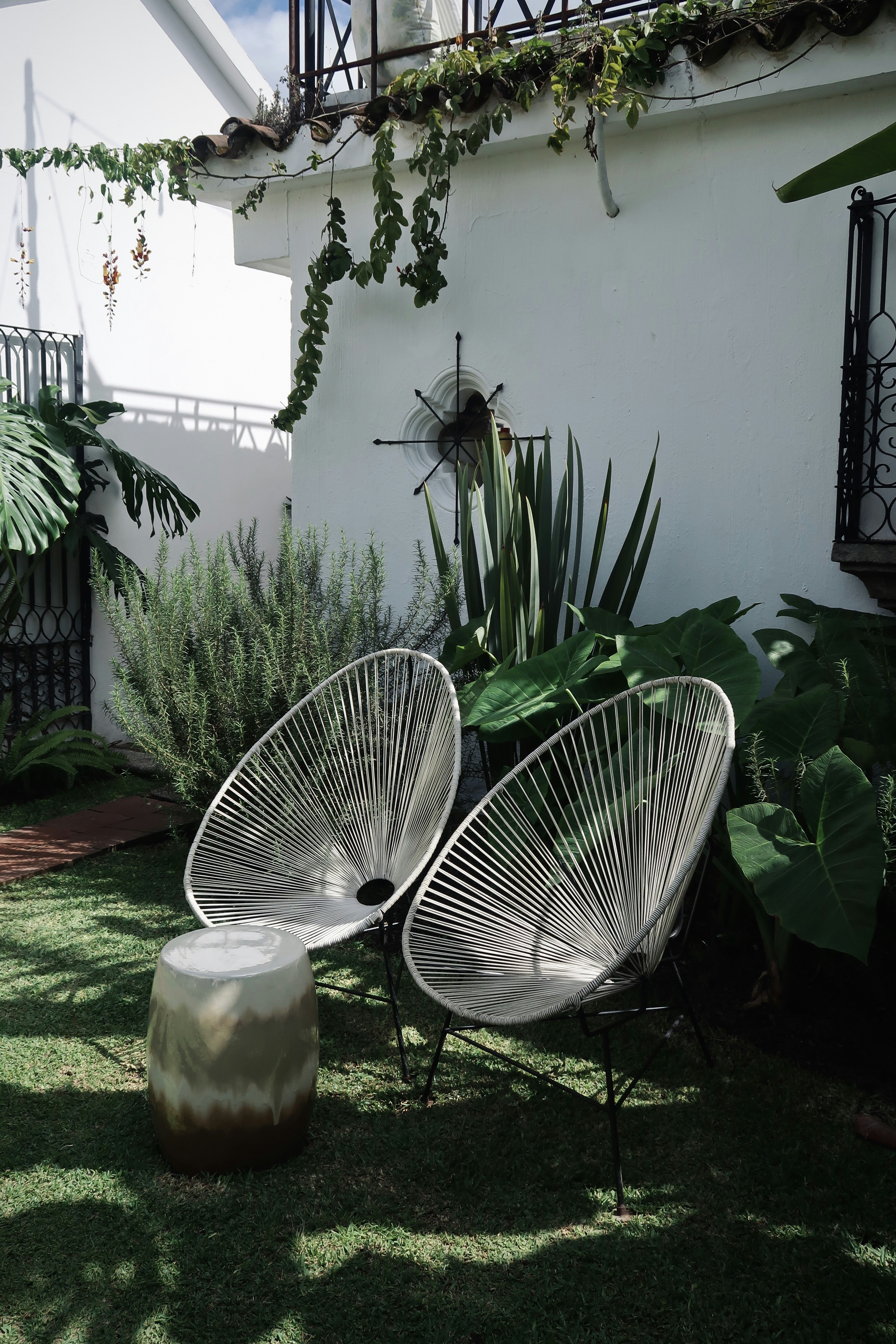 Sunlit Wire-Chair Duo in a Quiet Garden Courtyard