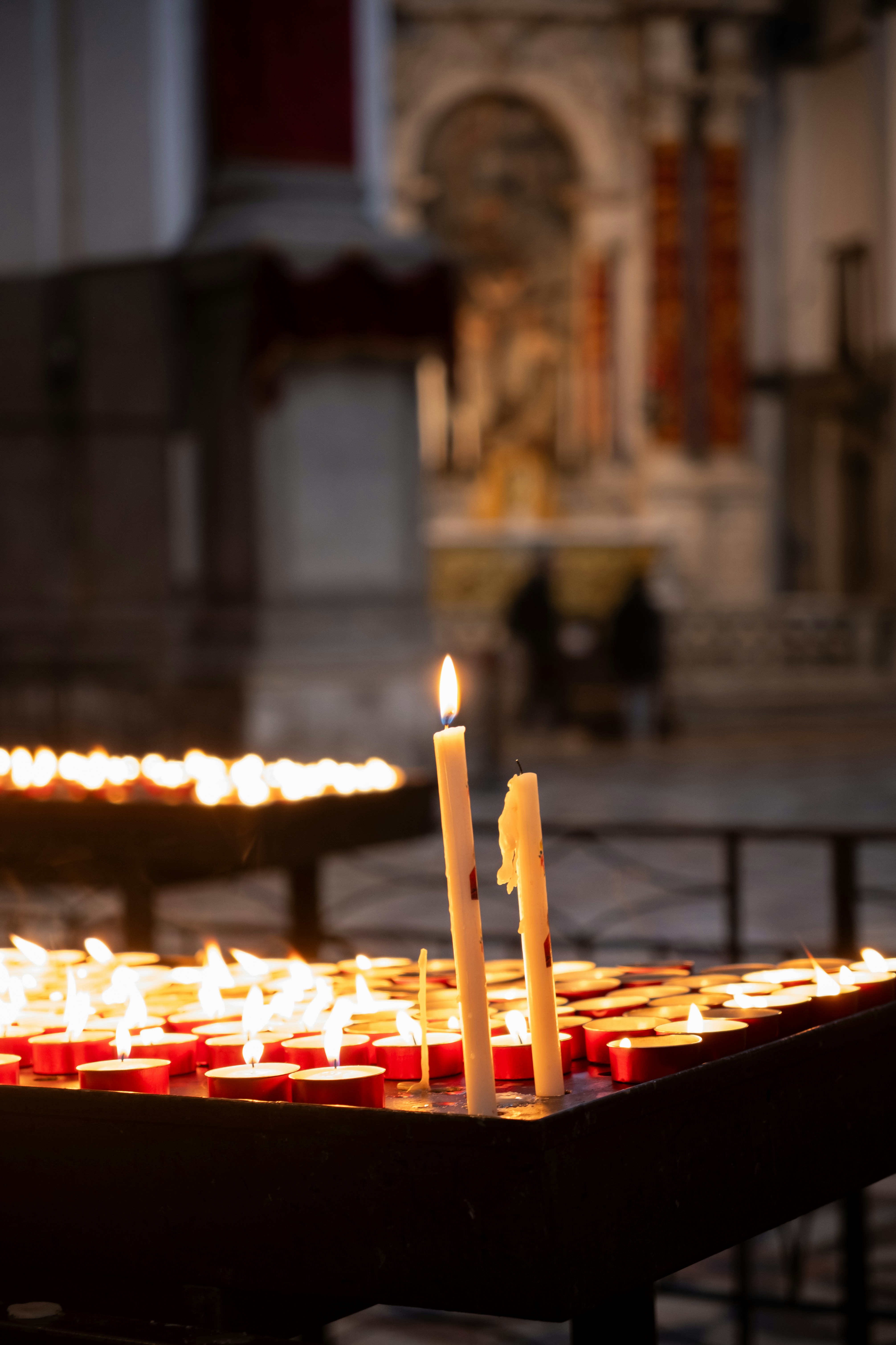Votive Flame in Soft Focus: Candles on a Quiet Altar Before an Arch