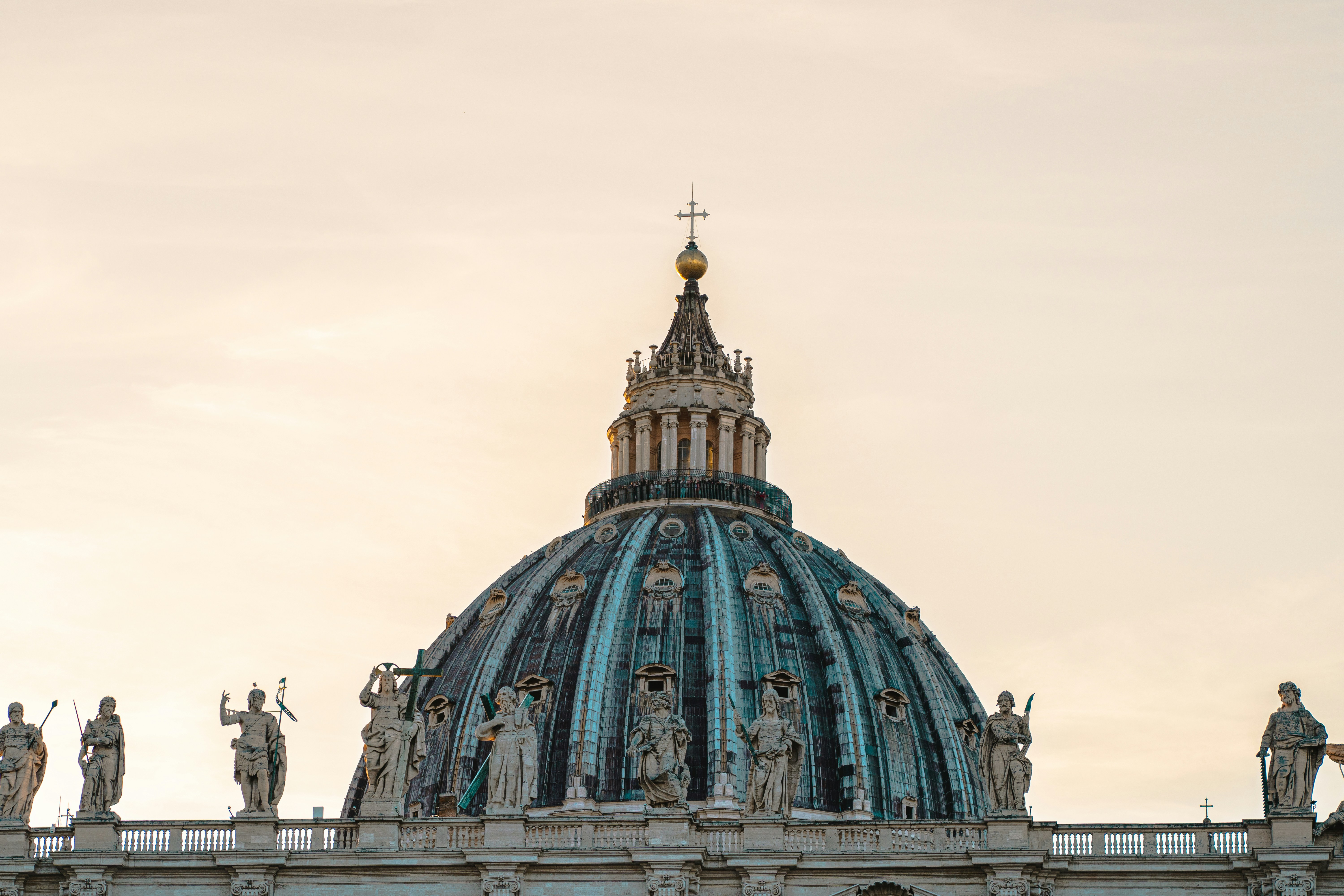 A very tall building with statues on top of it photo – Free Desktop ...