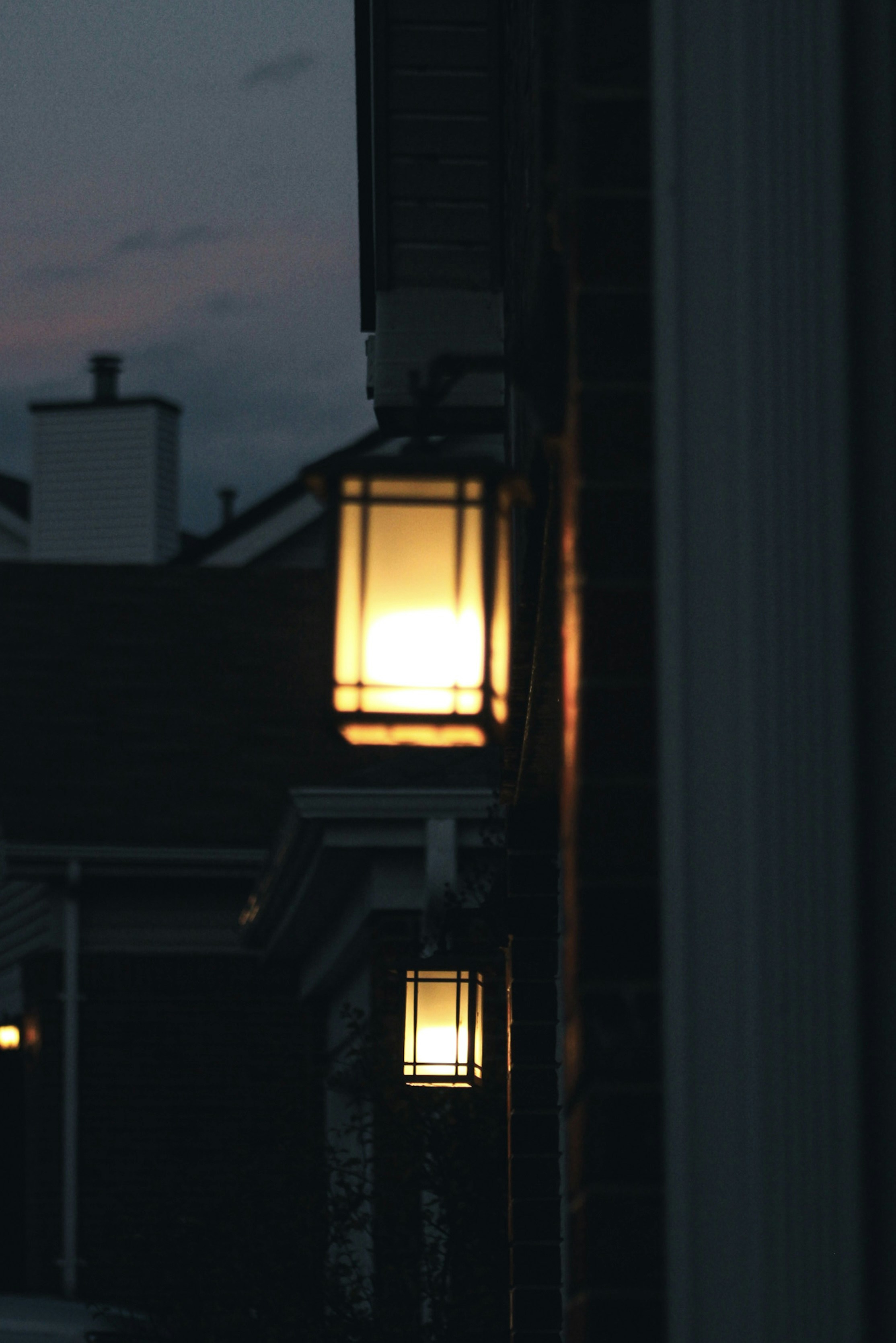 Dusk Lanterns Line a Shadowed Townhouse Wall