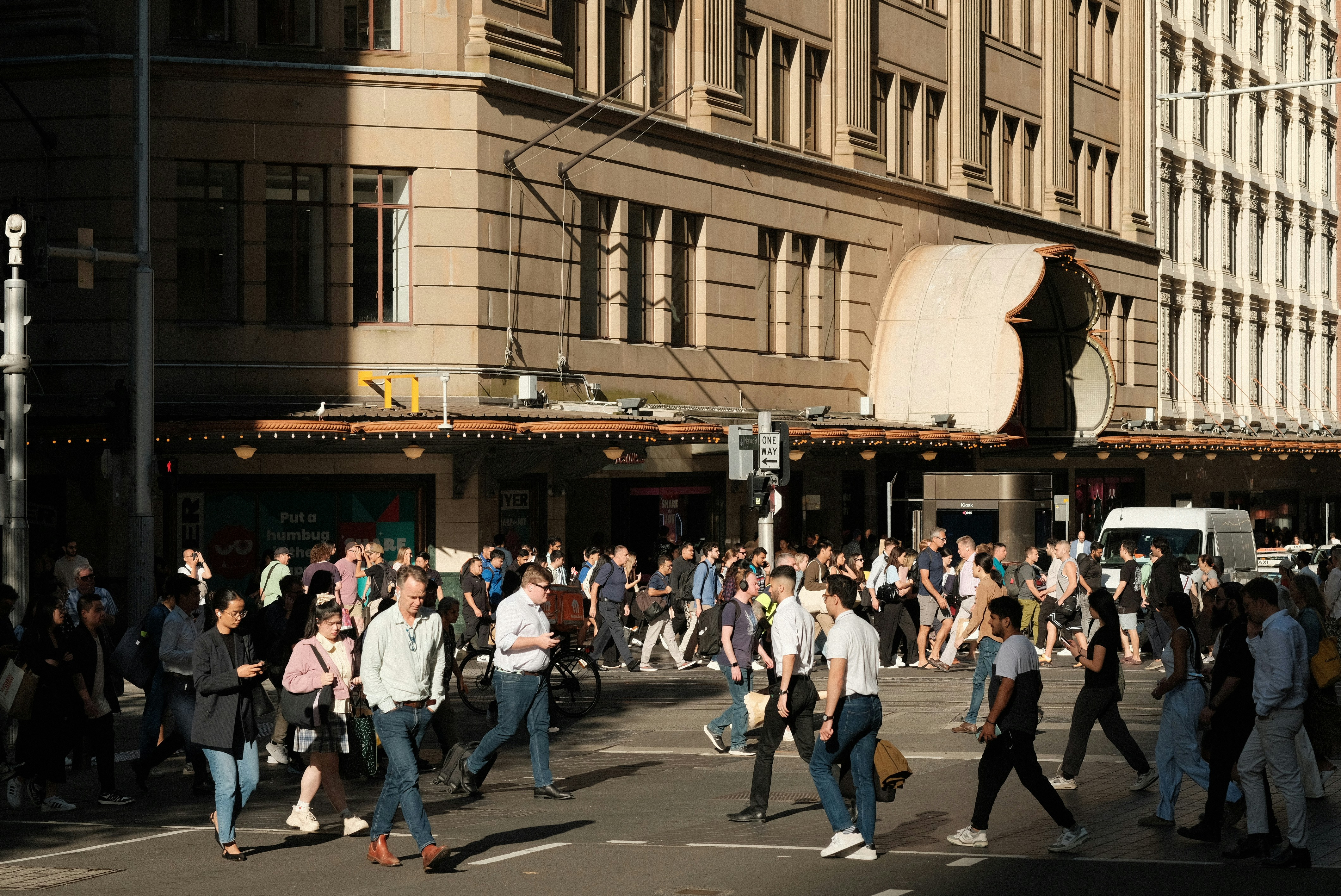 Crosswalk Chorus: Pedestrians Converge Beneath a Brick Arch