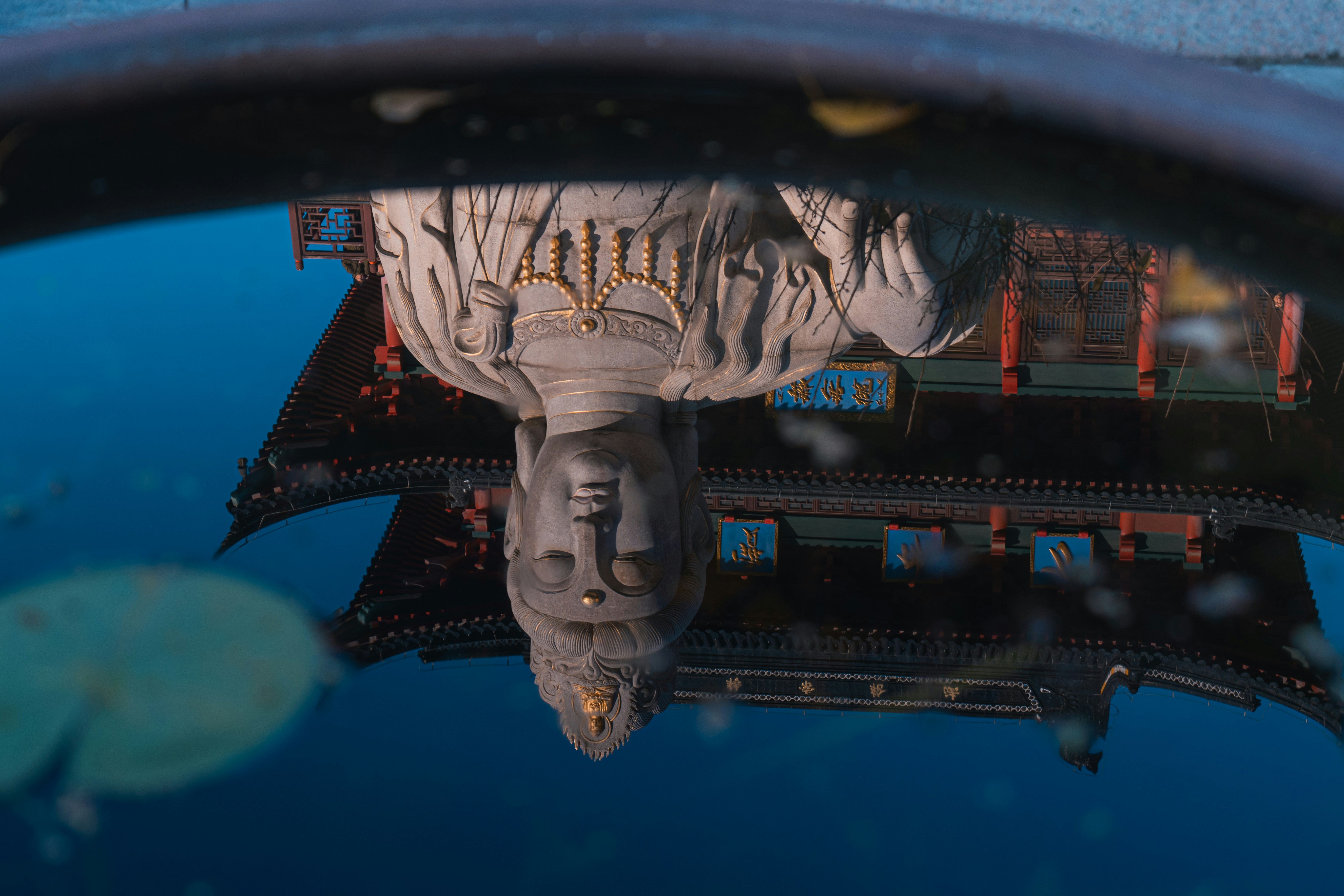 Blue Reverie: Buddha's Gaze Across Temple Waters