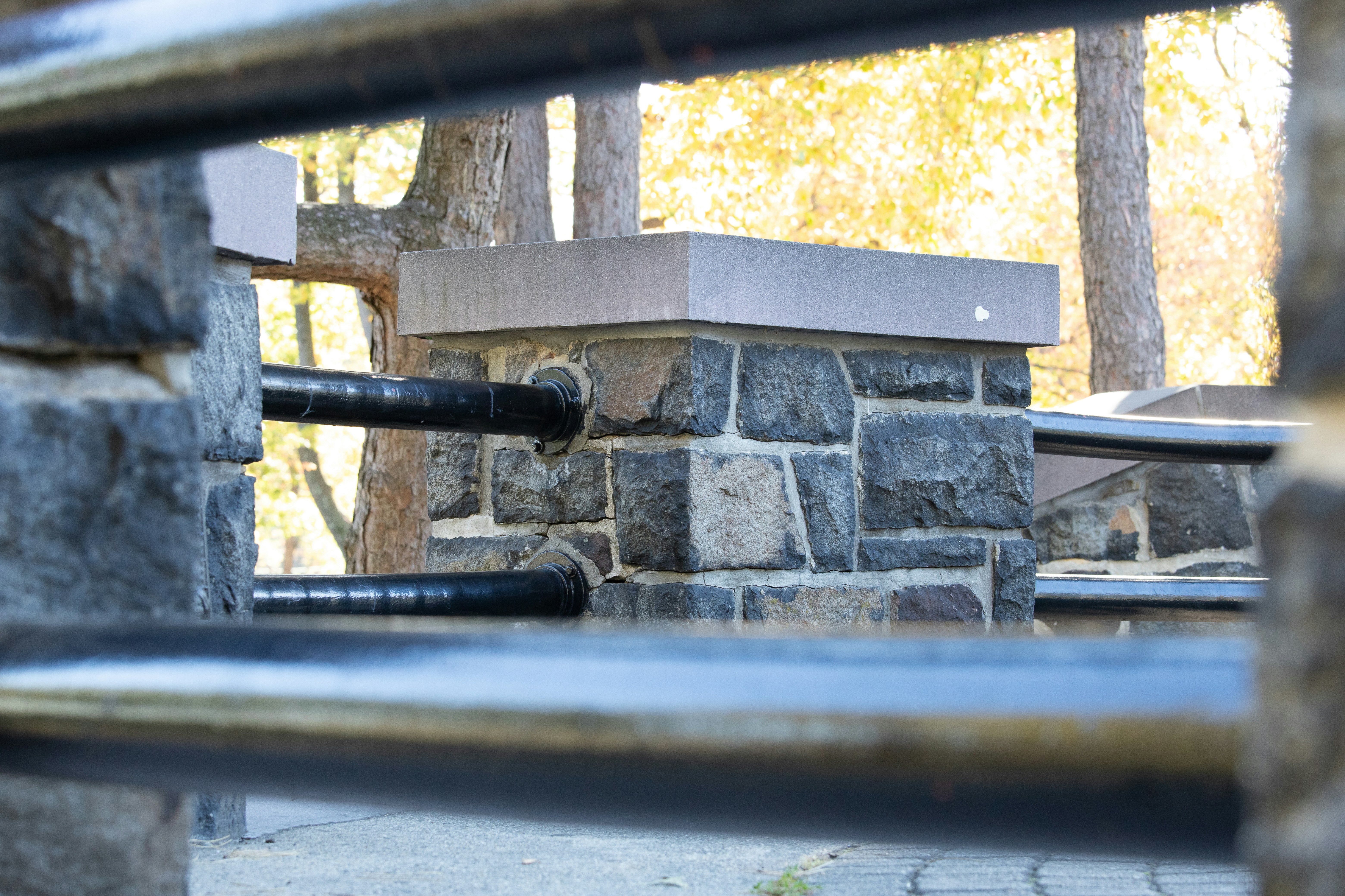 Stone Pillar Framed by Quiet Rails in Autumn Light