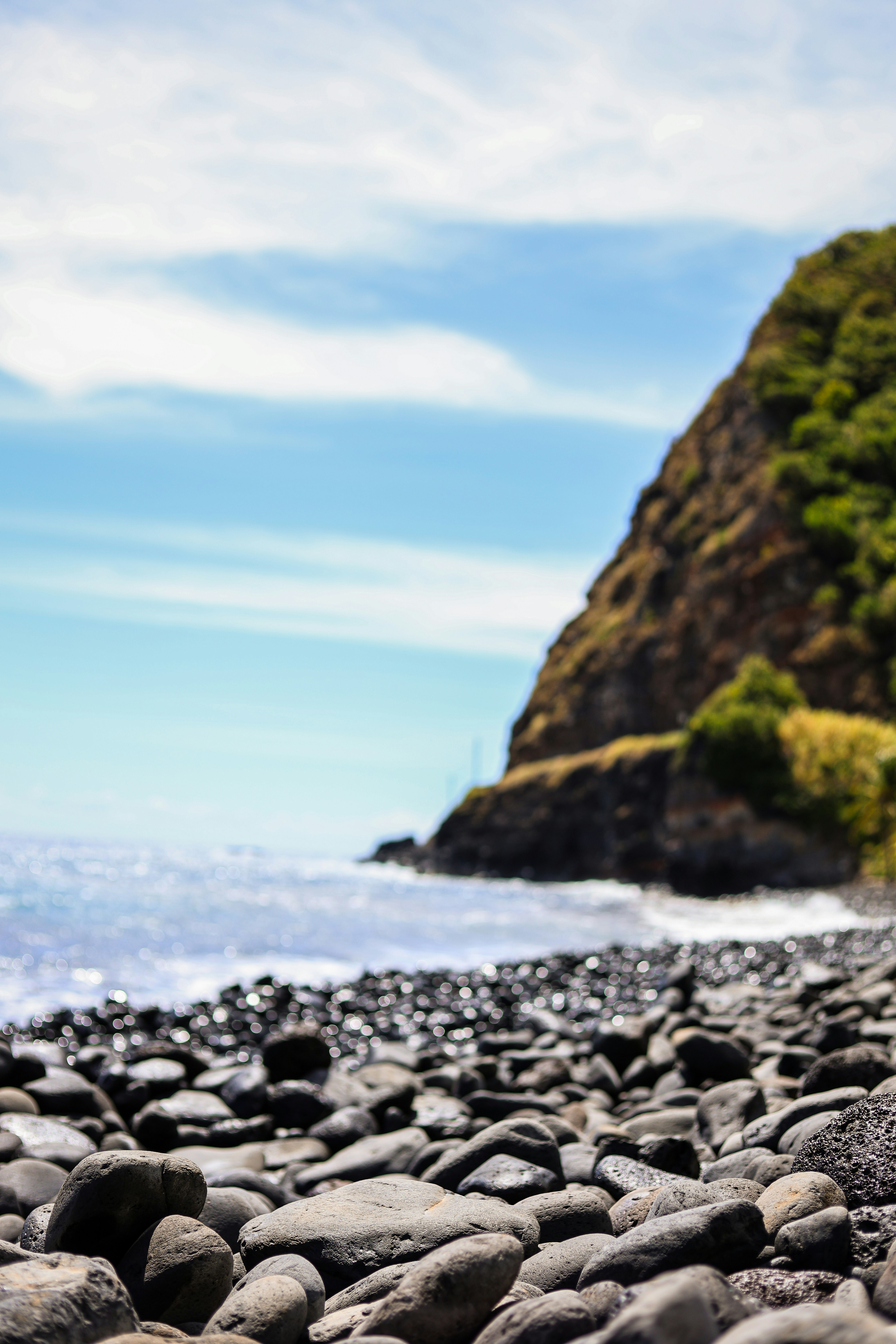 Una playa rocosa con una montaña al fondo foto – Imagen de Playa de ...