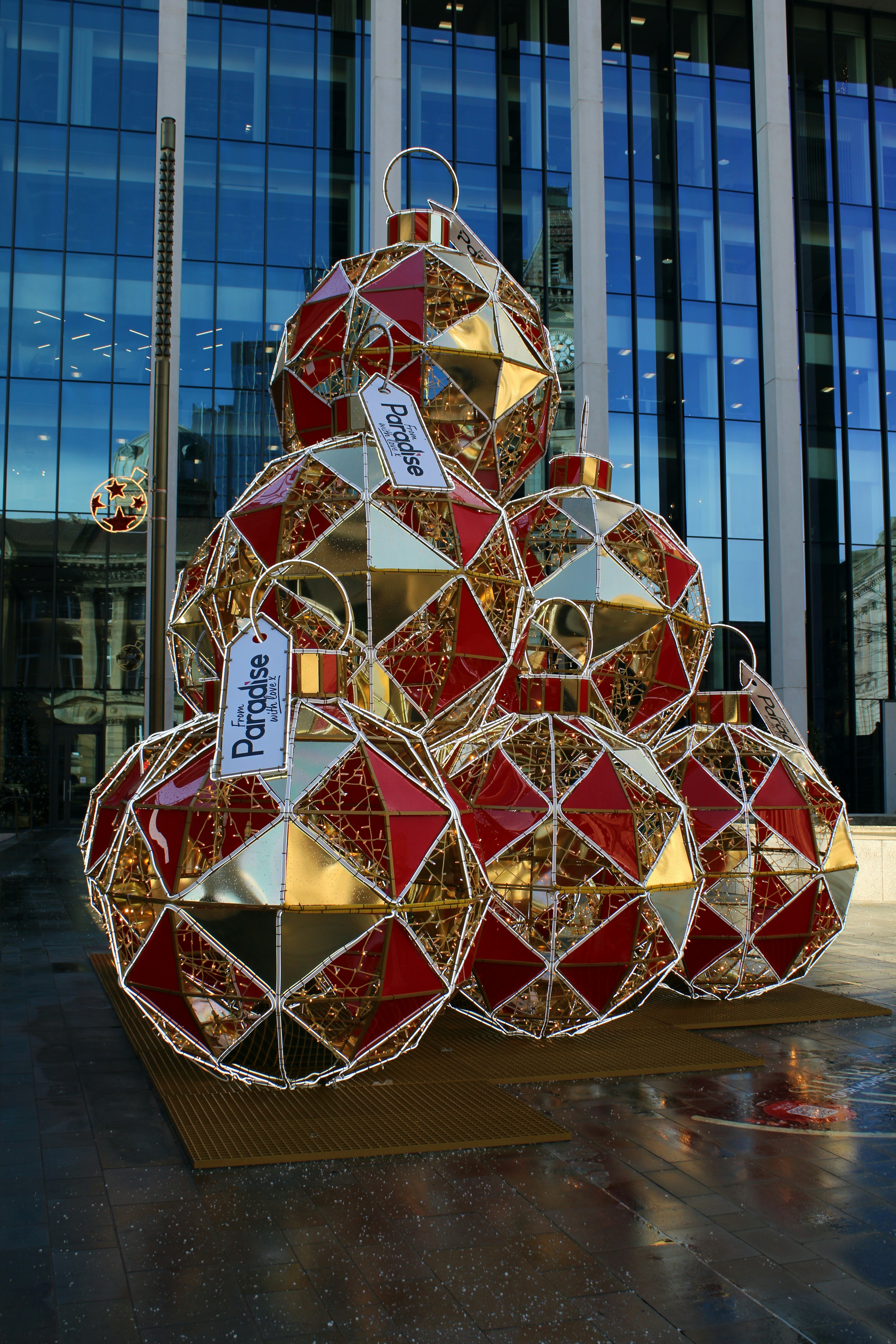 Geometric Lattice Christmas Ornament Beside a Glass Facade