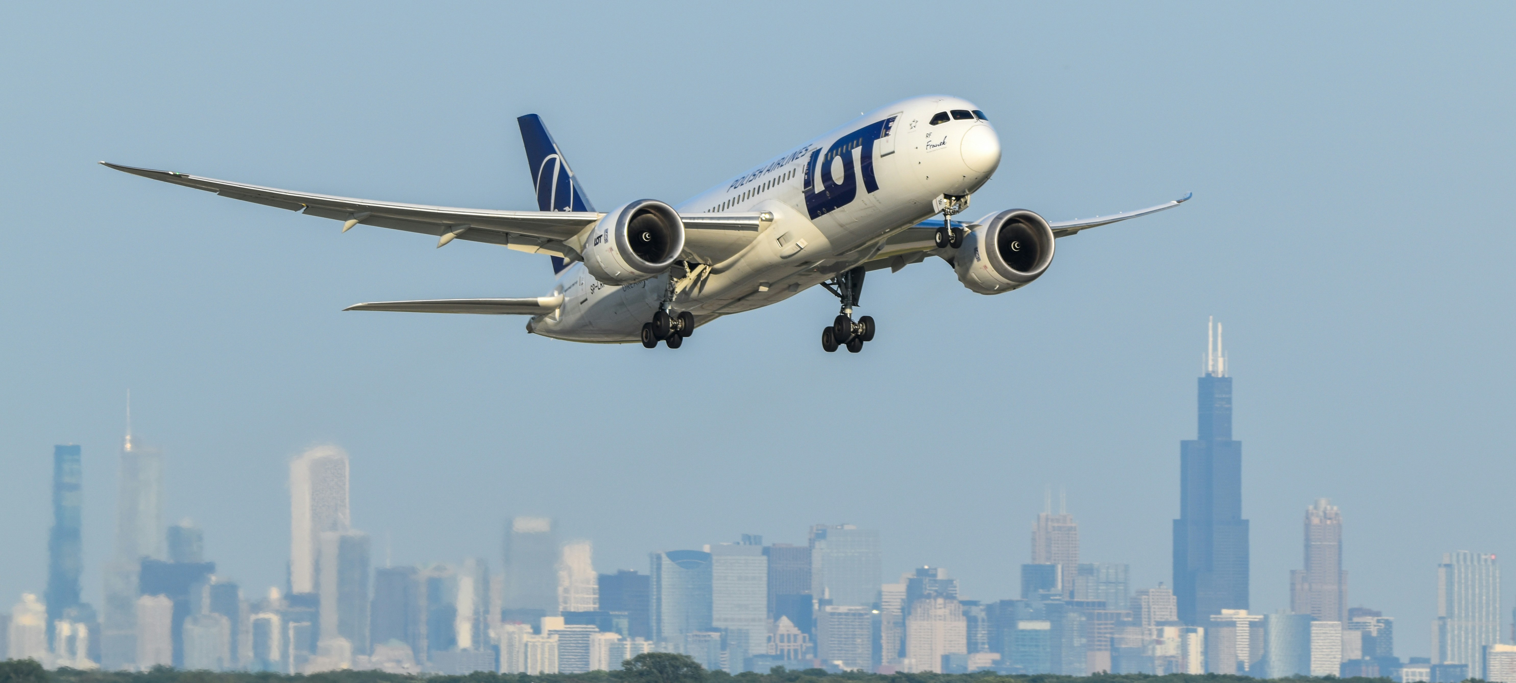 A large passenger jet flying over a city photo – Free Chicago Image on ...