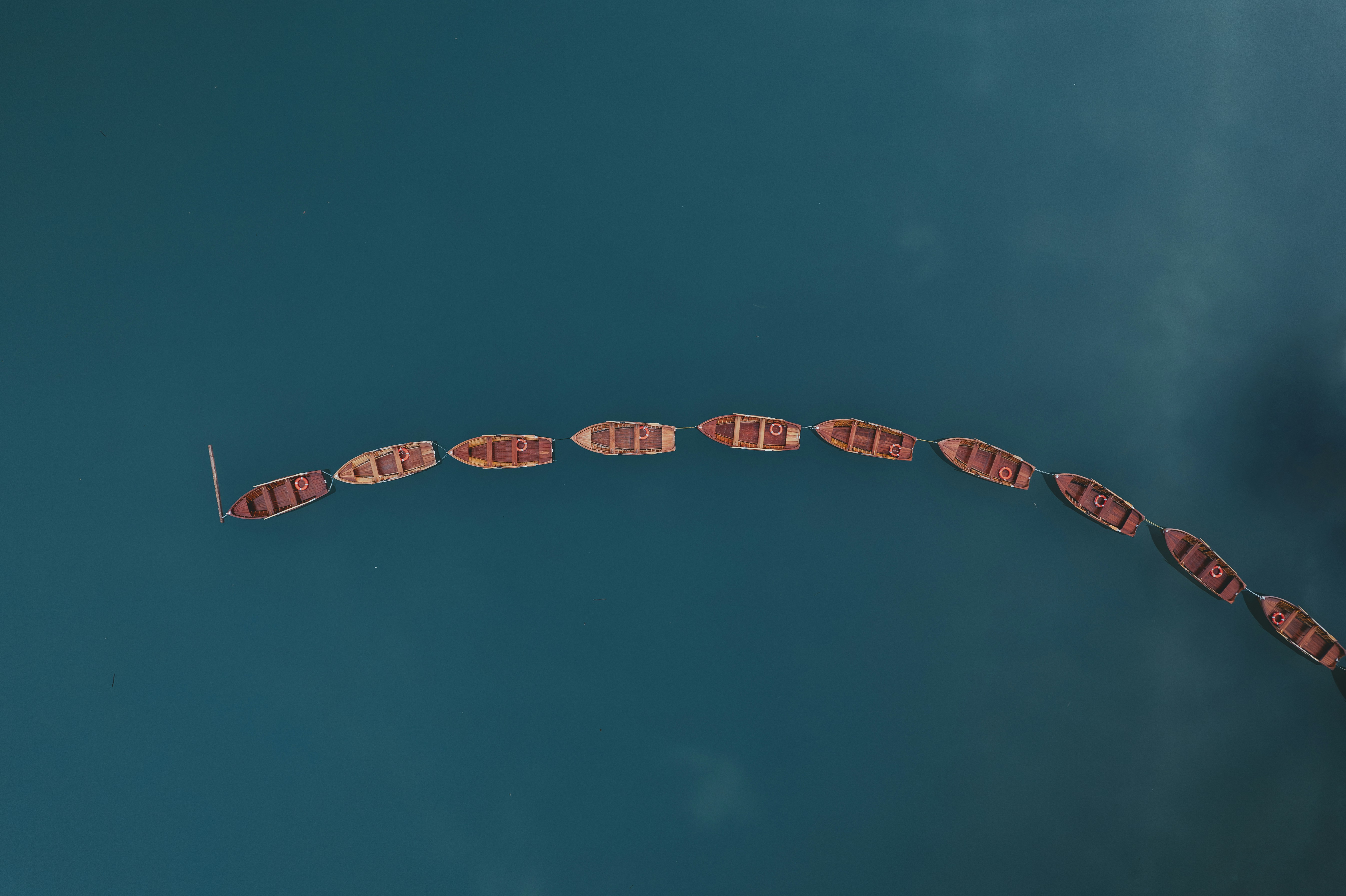 A group of red boats floating on top of a body of water photo – Free ...