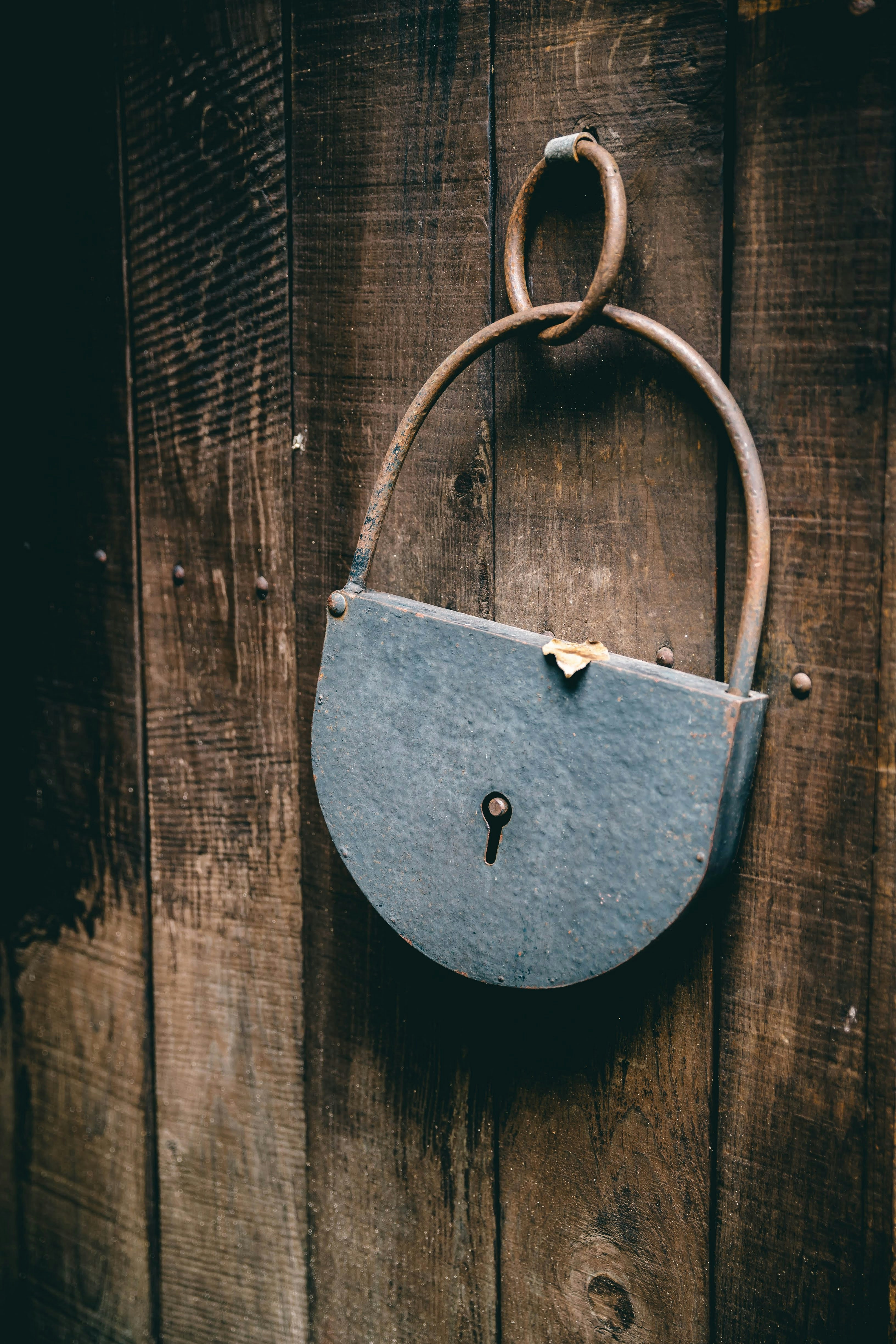 Weathered Padlock on a Timber Door: A Quiet Sentinel of Time
