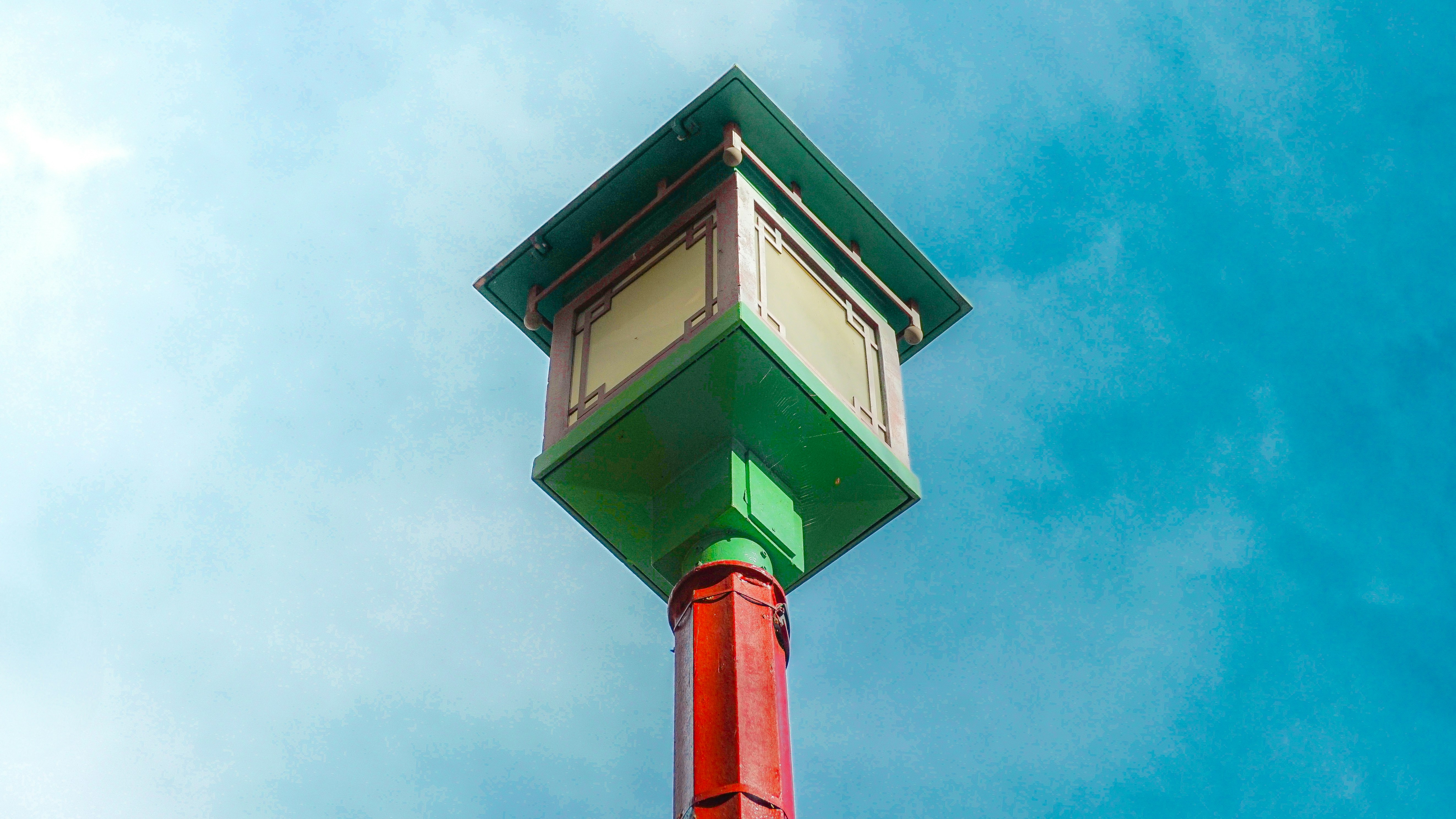 A tall red and green pole with a clock on top photo – Free Sky Image on ...