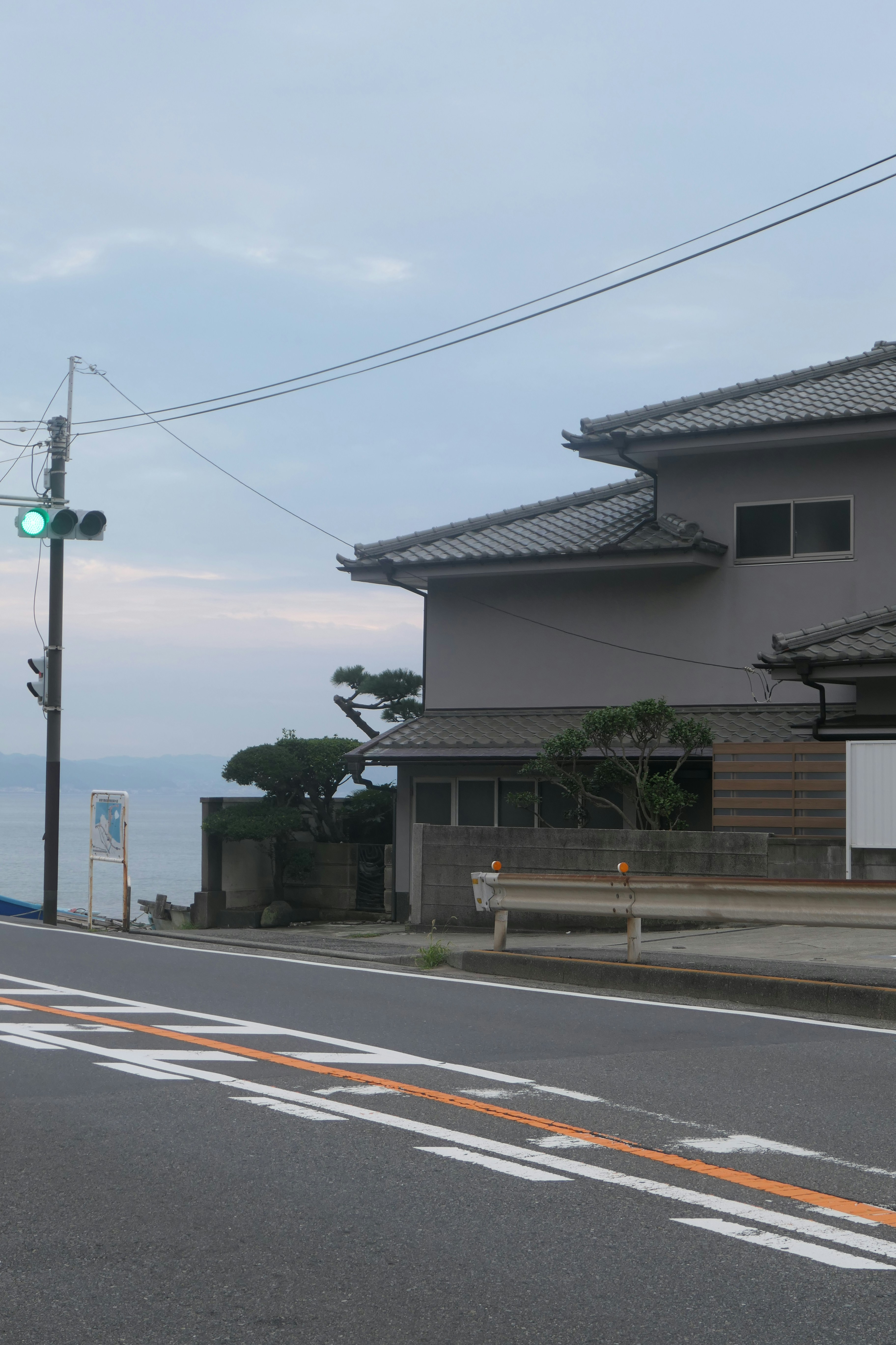A street corner with a building and a green traffic light
