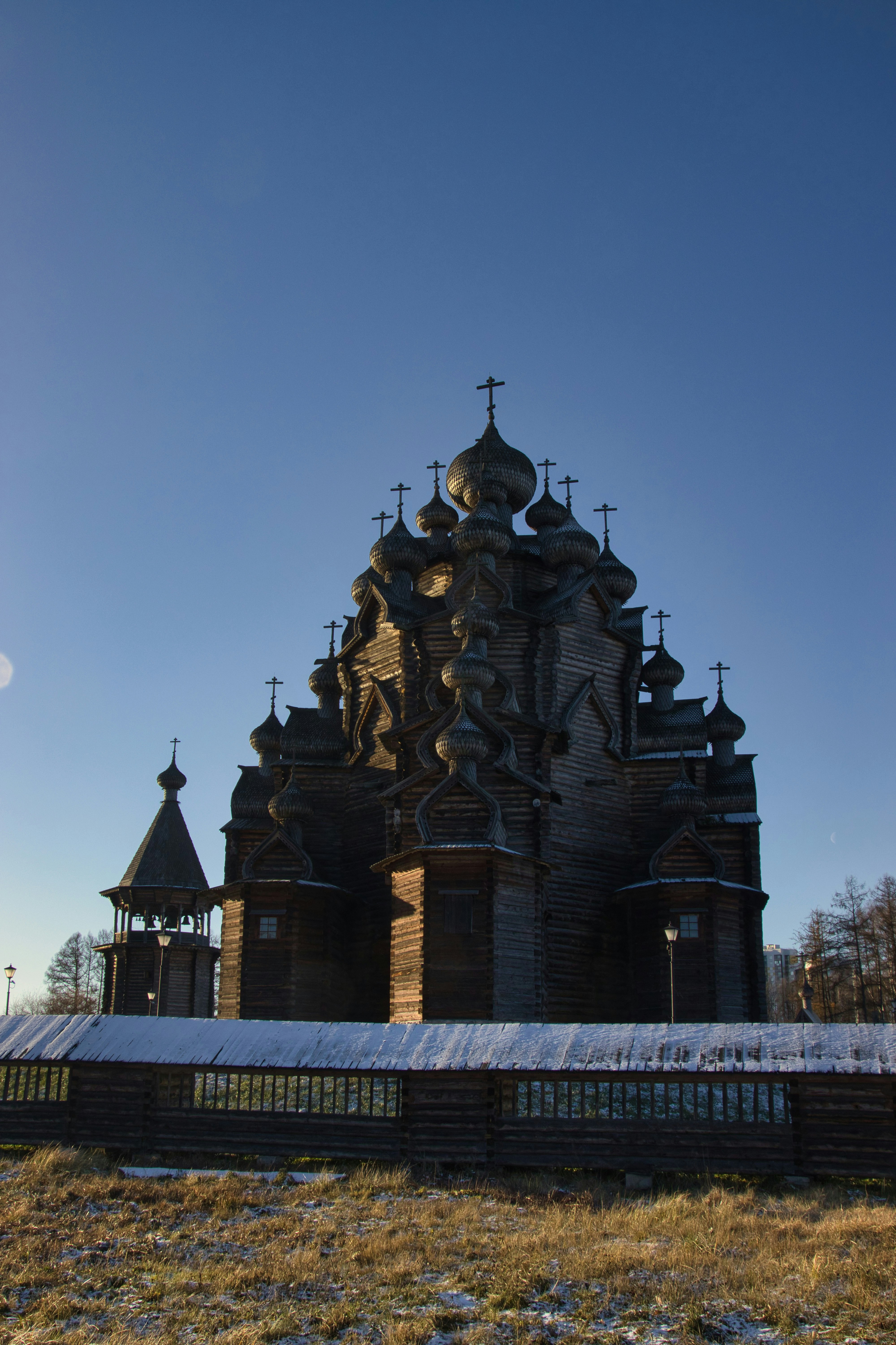 Timber Cathedral of Onion Domes Beneath a Clear Blue Sky