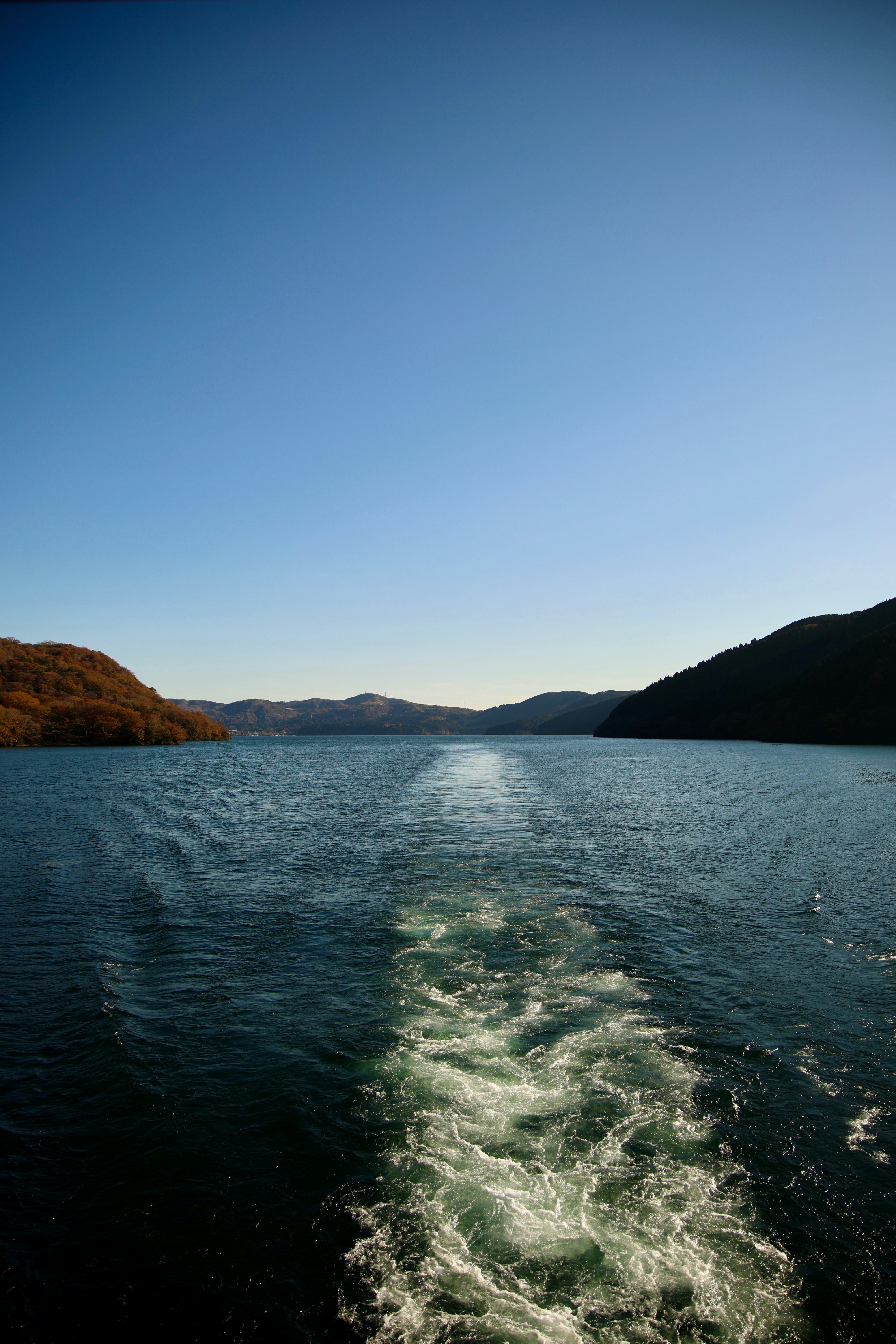 Wake-Traced Horizon: A Quiet Lake Between Forested Ridges