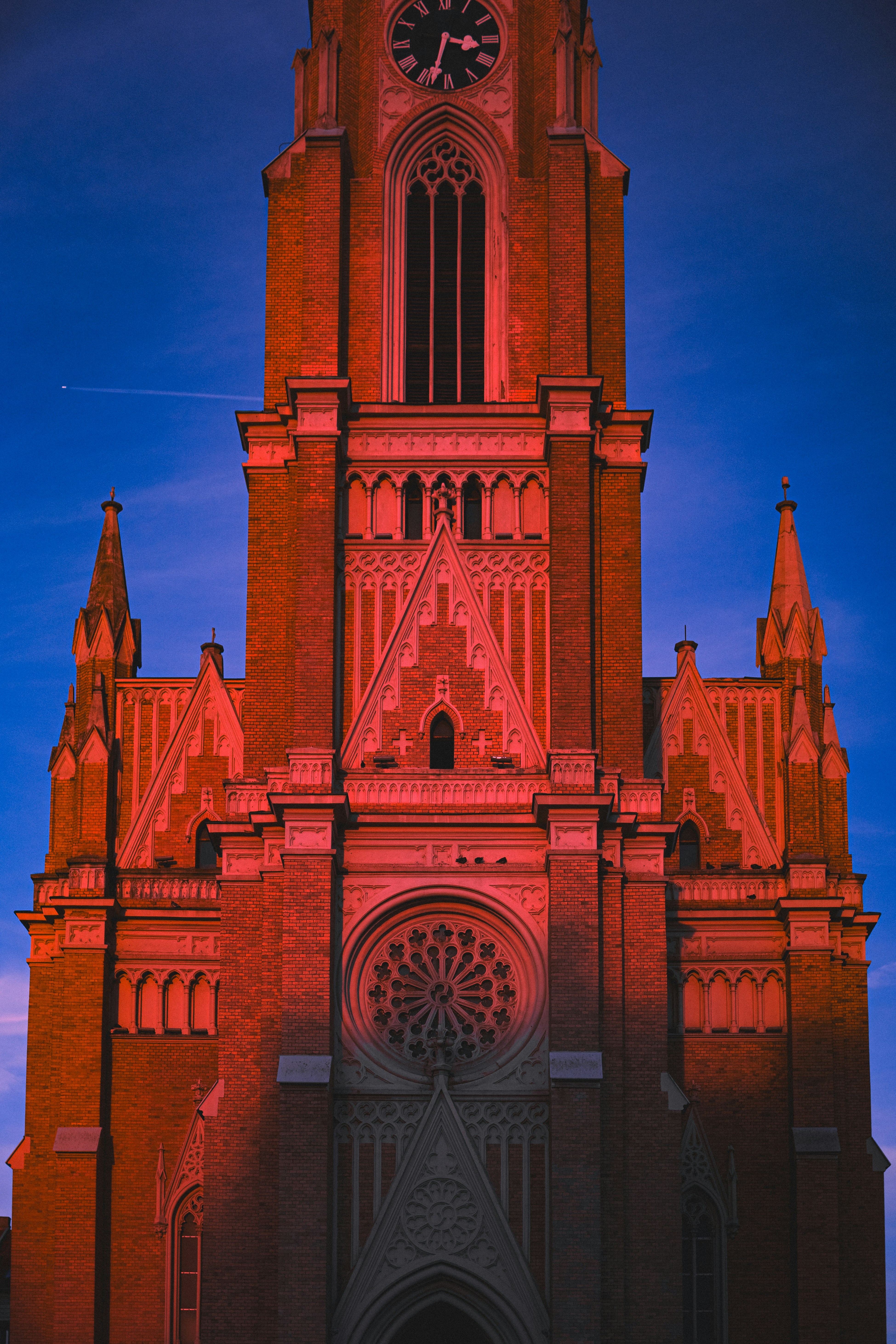 Crimson Facade: Gothic Clocktower Under a Sapphire Dusk