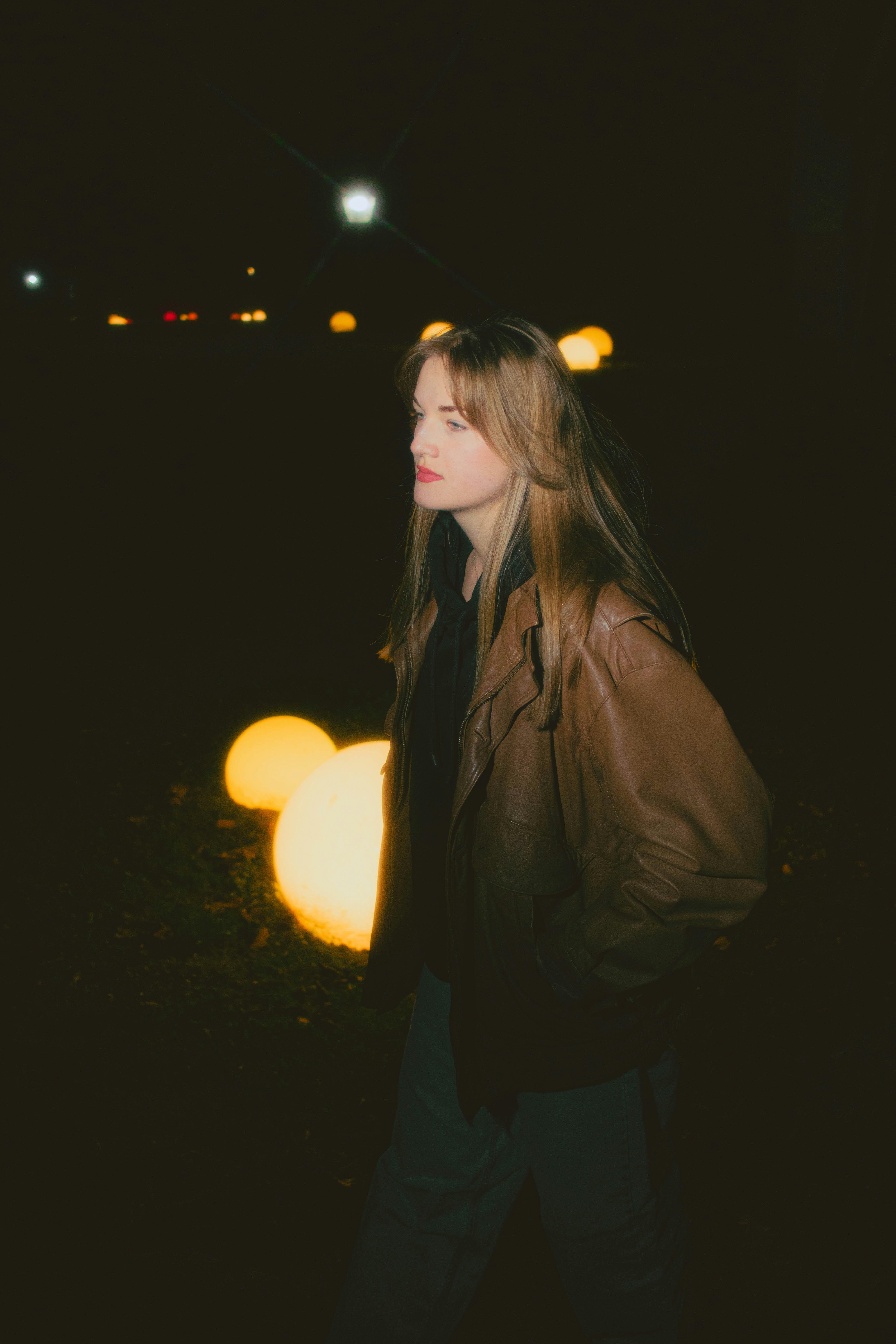 A woman standing in the dark holding a lit object photo – Free Woman ...