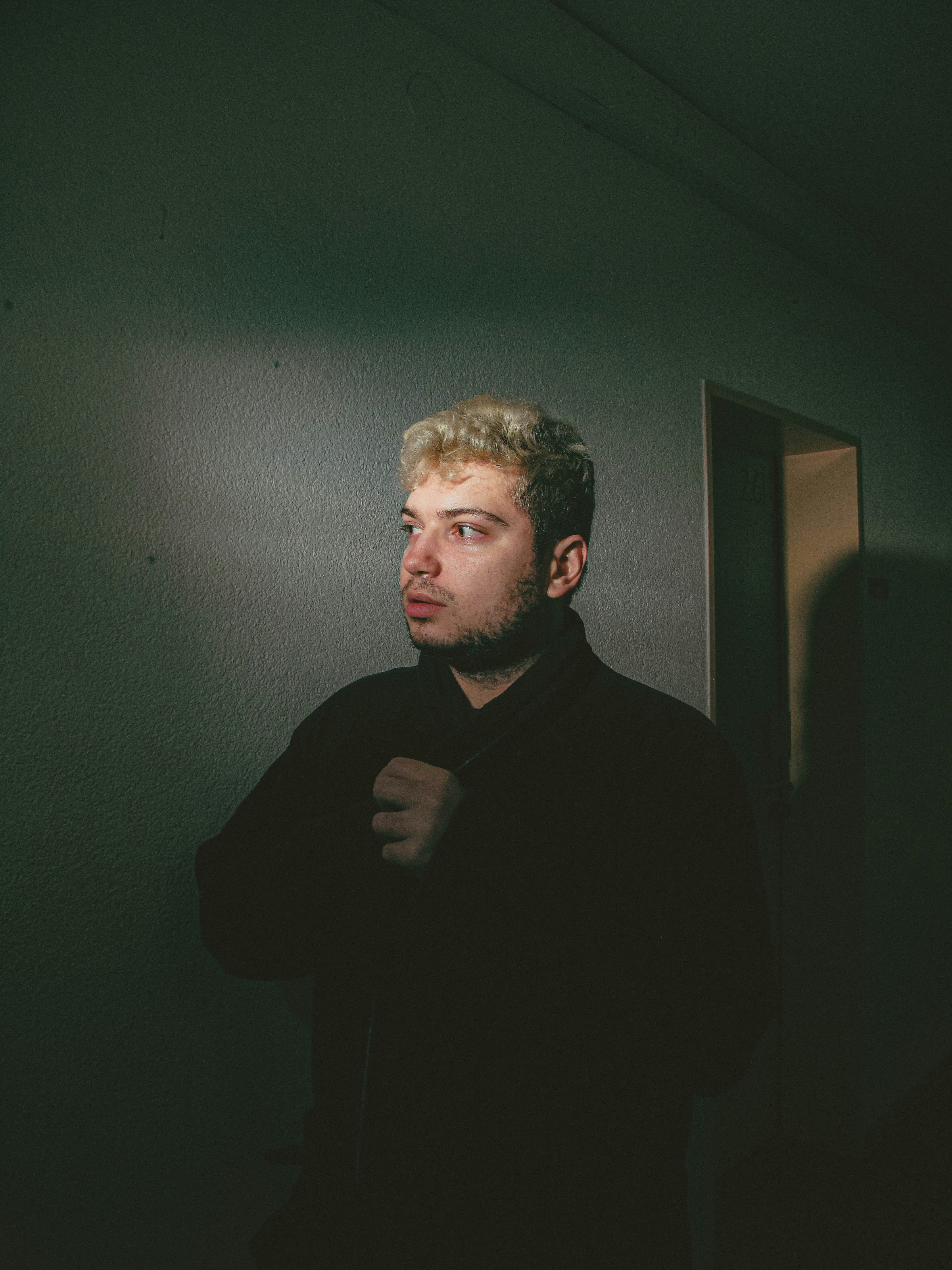 A man standing in front of a mirror in a dark room photo – Free ...