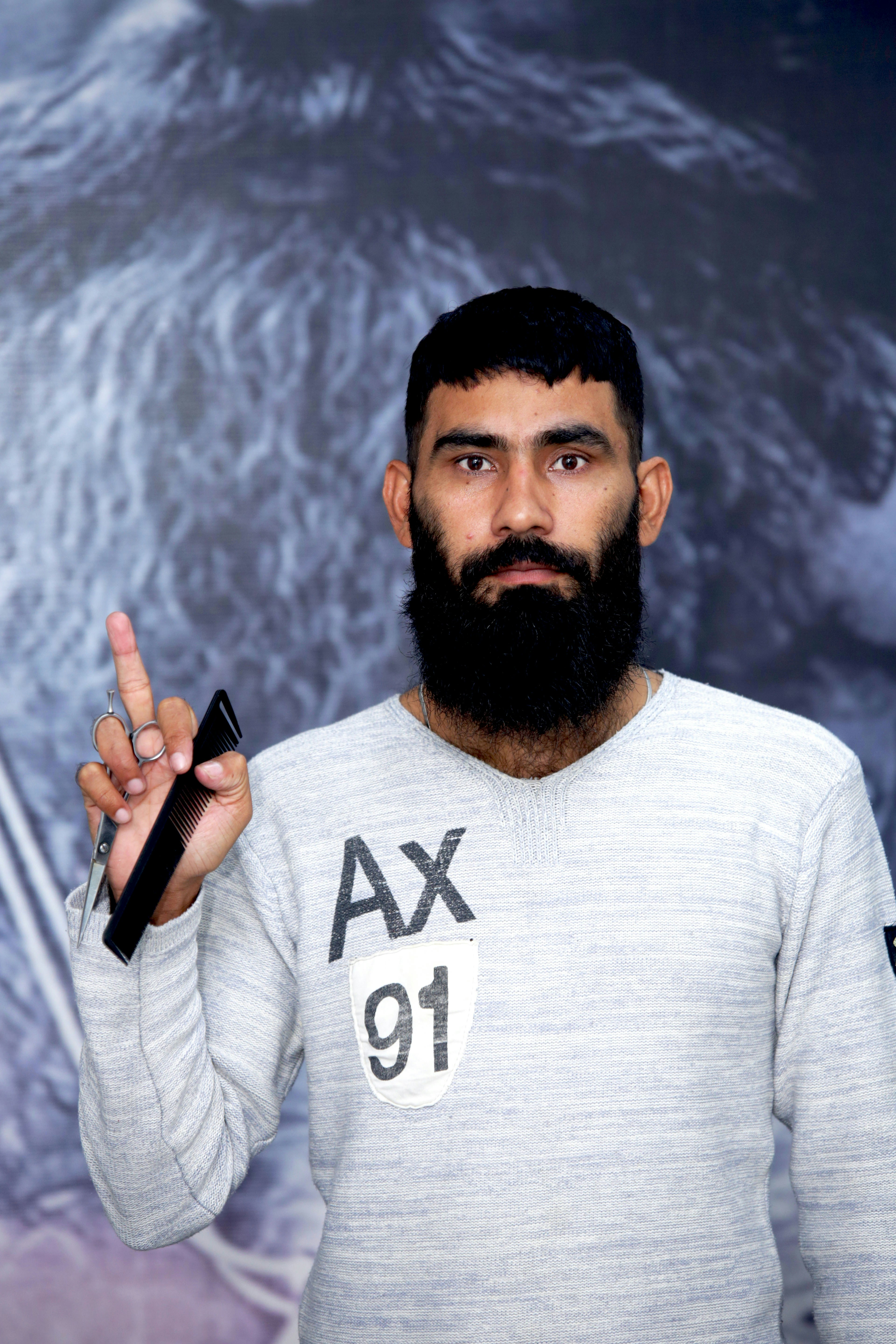 A man with a goatee and a beard holding up a peace sign photo – Free ...