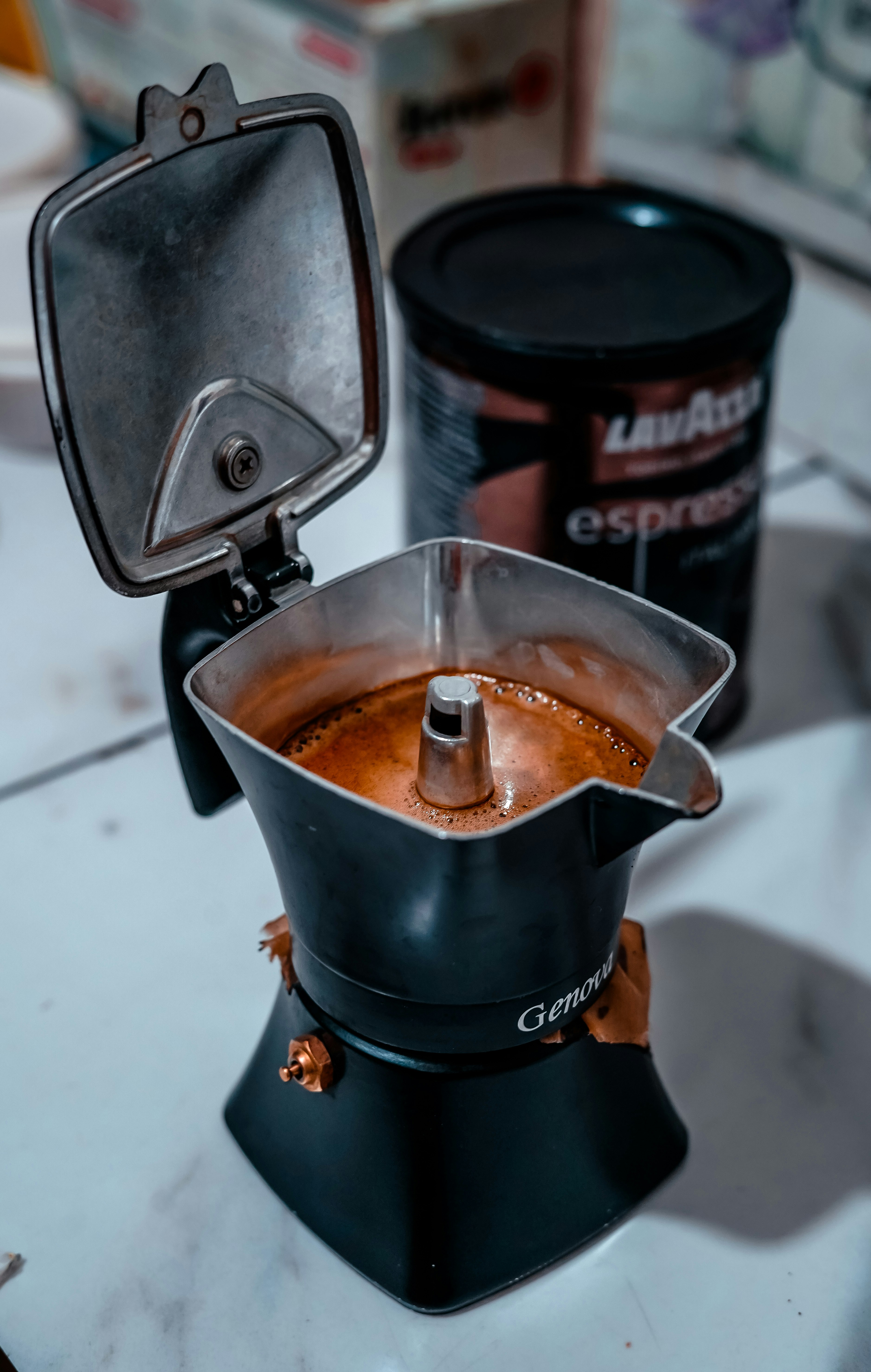 Open-Lid Moka Pot on Marble Counter, Brewing Rich Espresso Amid Kitchen Clutter