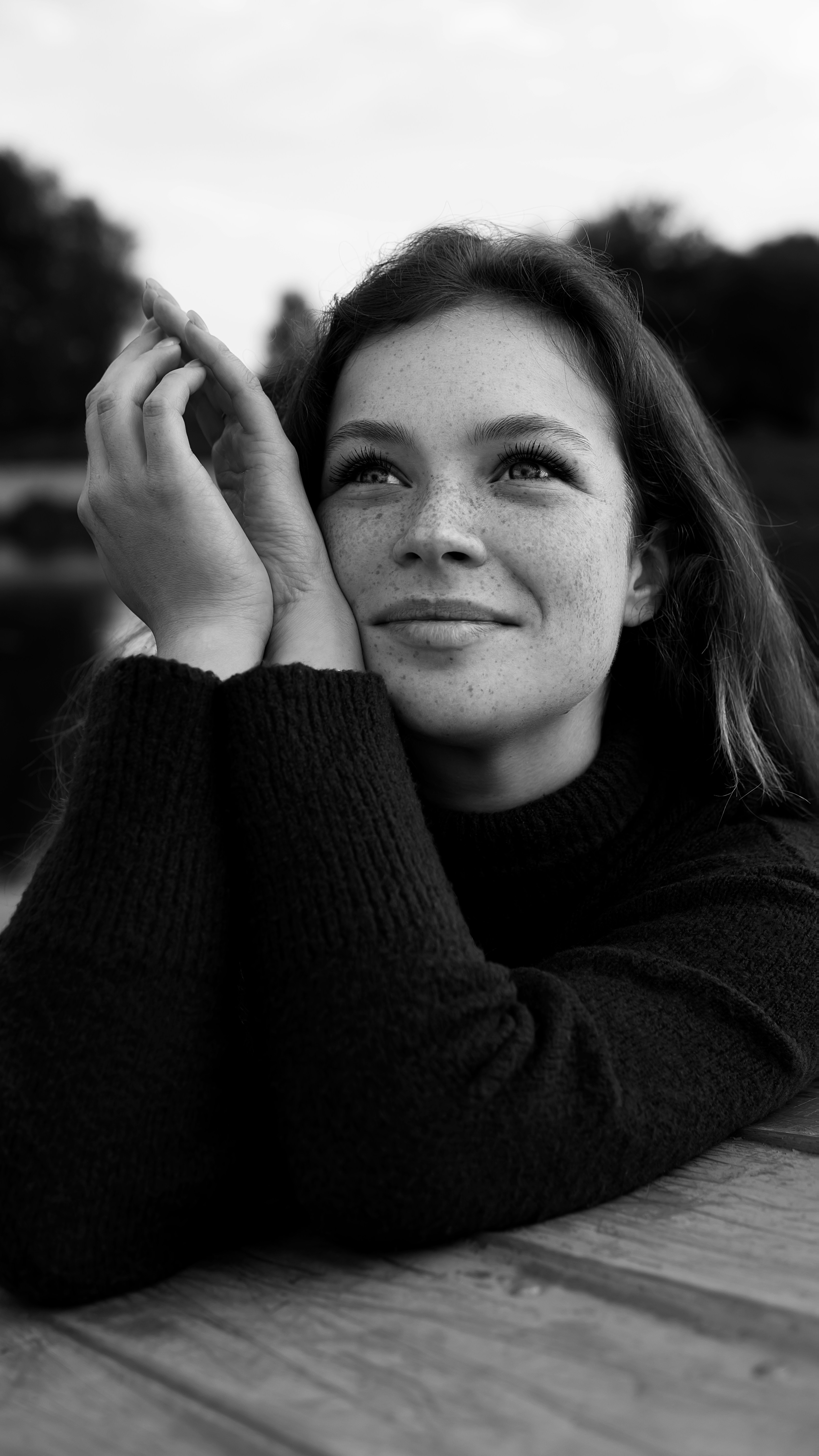 A black and white photo of a woman sitting on a dock photo – Free Face ...