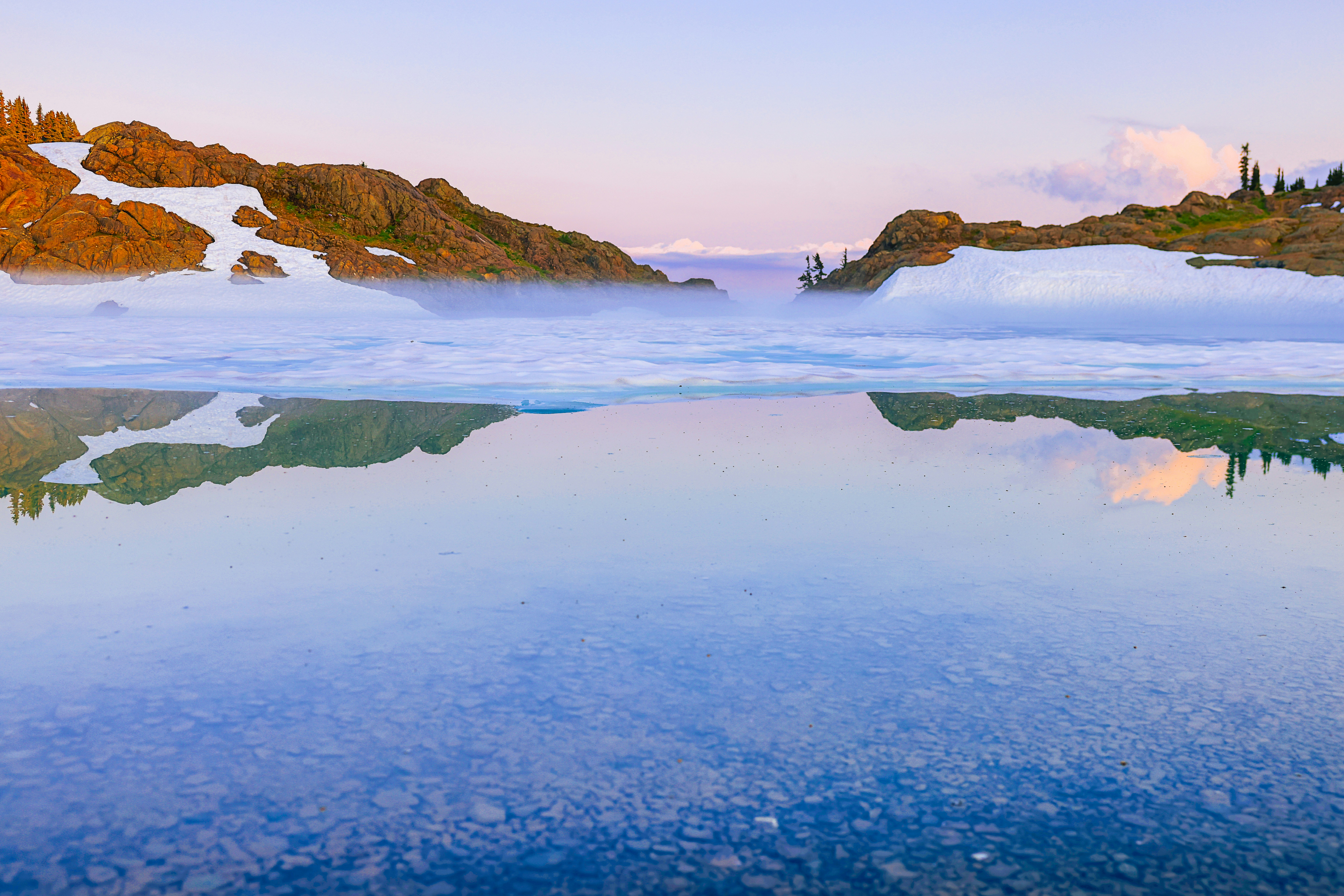 A body of water surrounded by snow covered mountains photo – Free ...