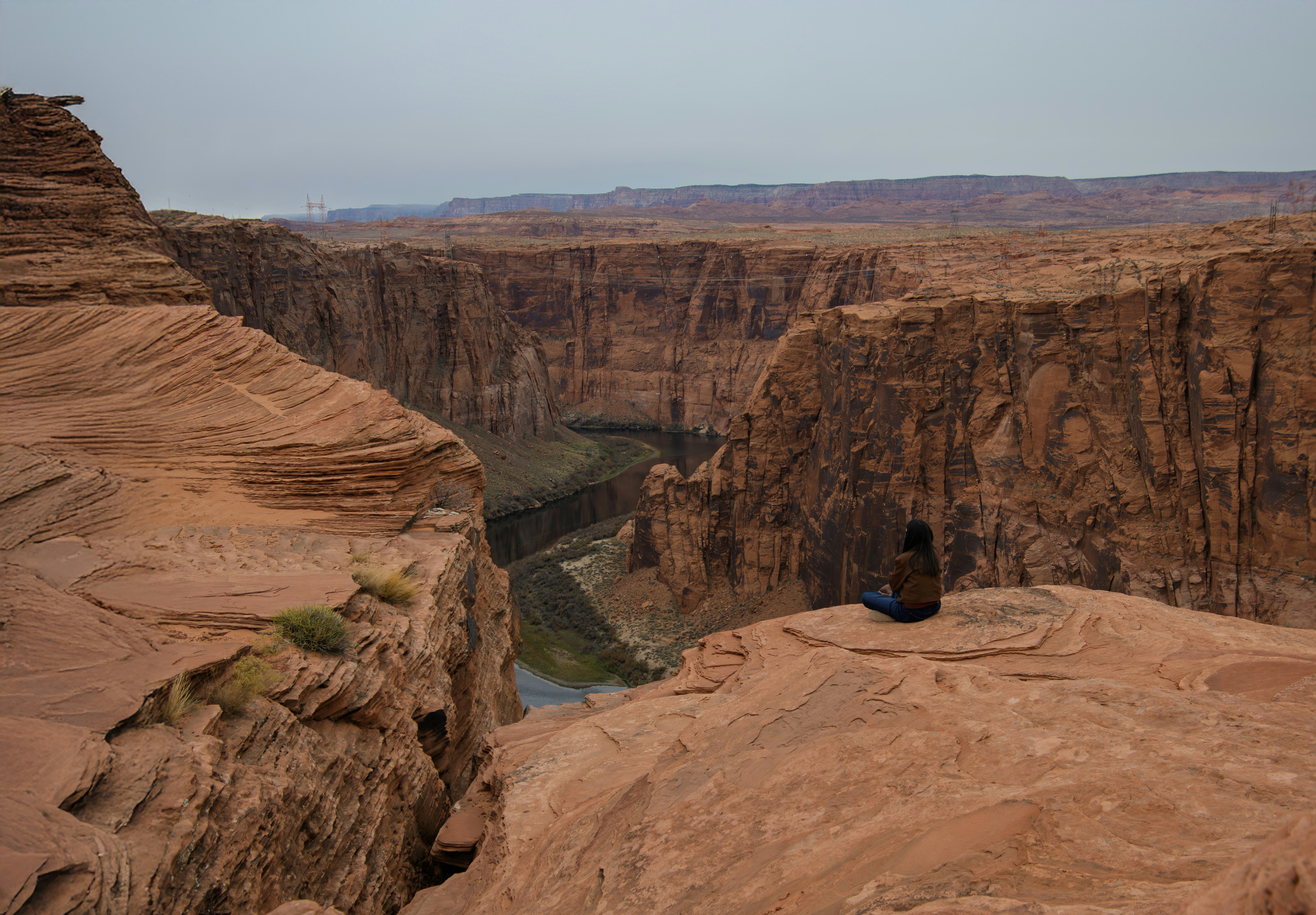A person sitting on a cliff overlooking a canyon photo – Free Arizona ...
