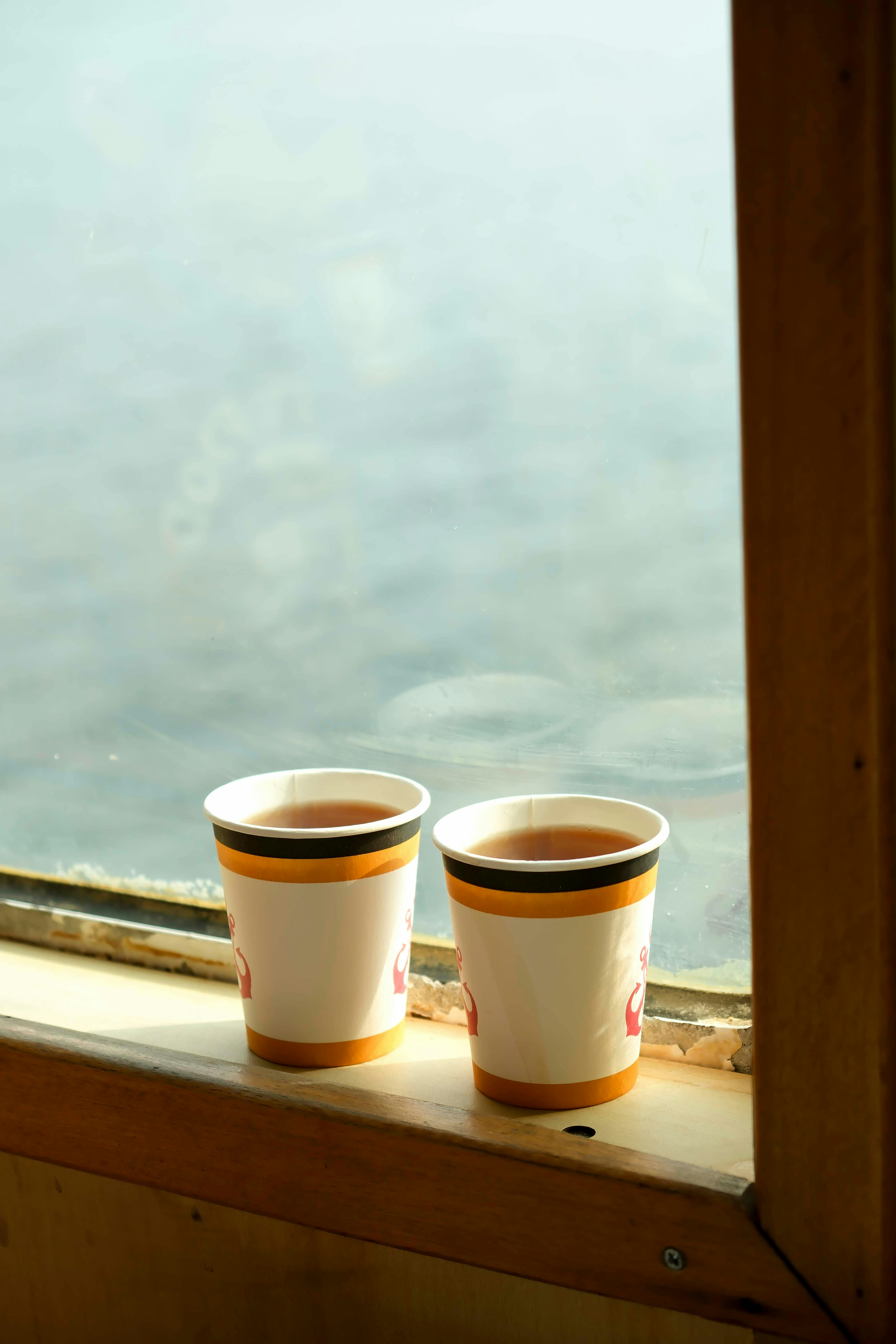 Two cups of coffee sitting on a window sill photo – Free Islamabad ...