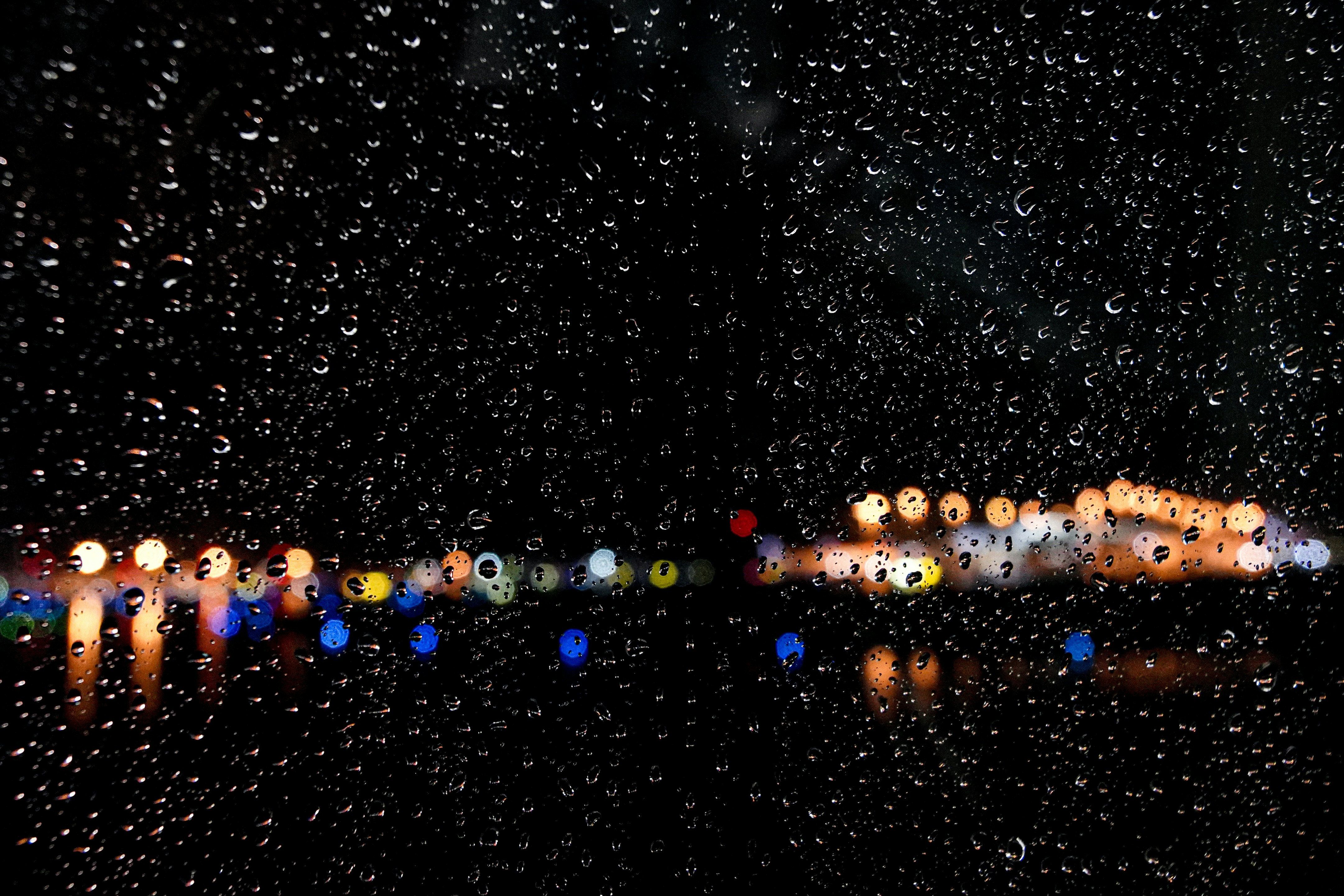Rain-Dusted Glass: Night City Lights through a Veil of Droplets