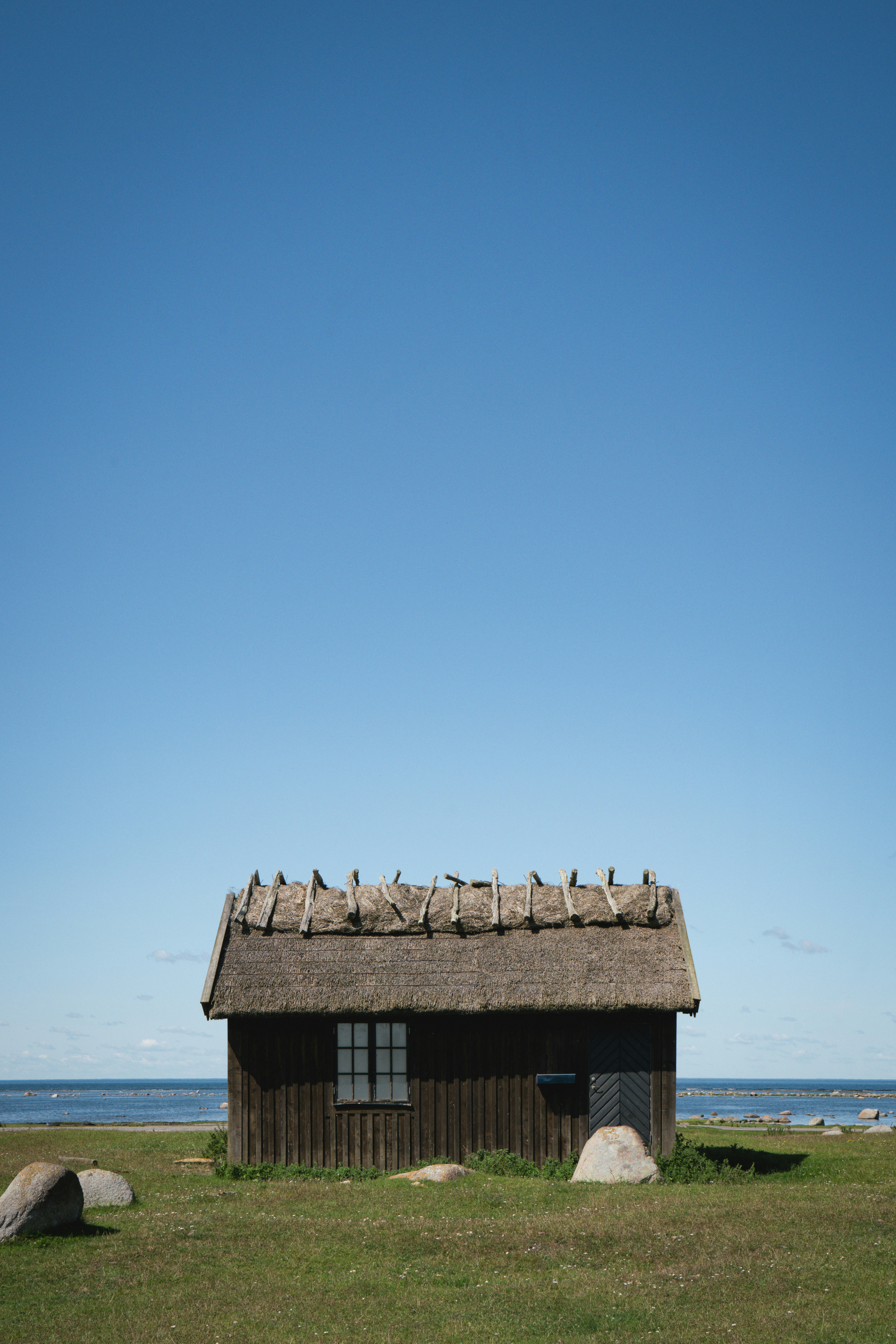 Thatched Sea Cabin Quietly Poised Against a Wide Blue Horizon