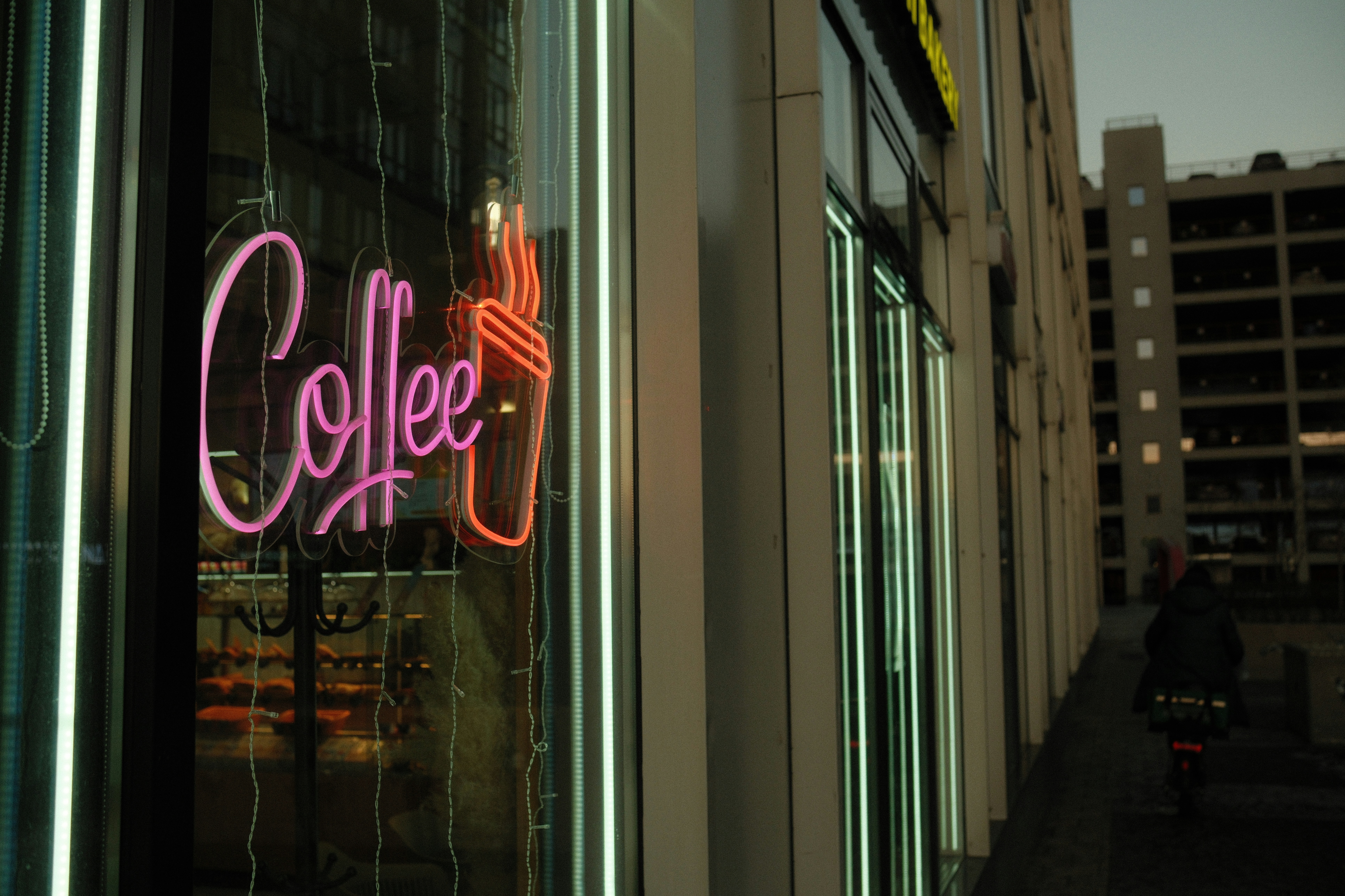 Neon Coffee Sign Illuminates a Dim Streetfront