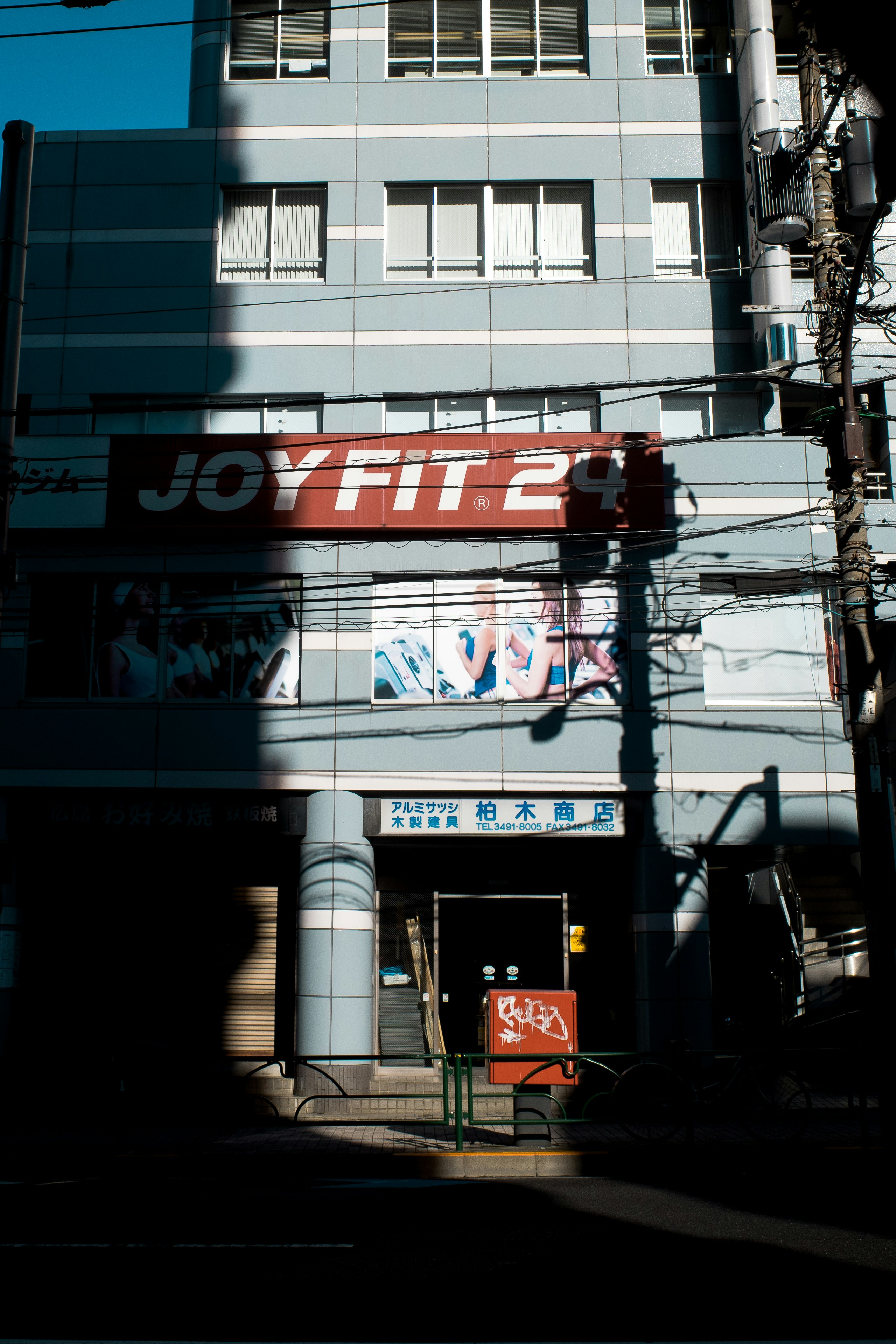 Shadows on a Blue Facade: JOYFIT 24 Under Wires