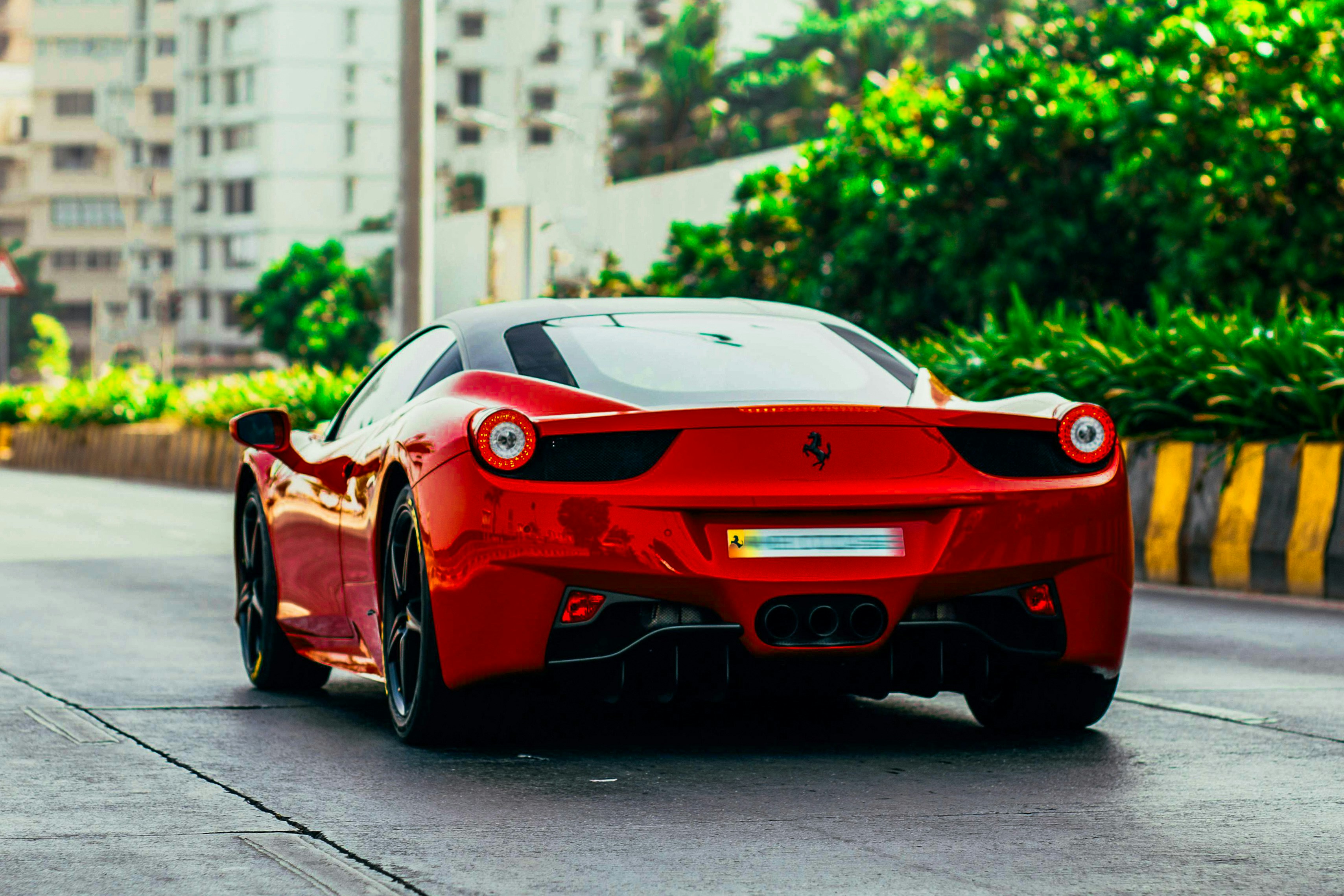 A red sports car driving down a street photo – Free Sports car Image on ...