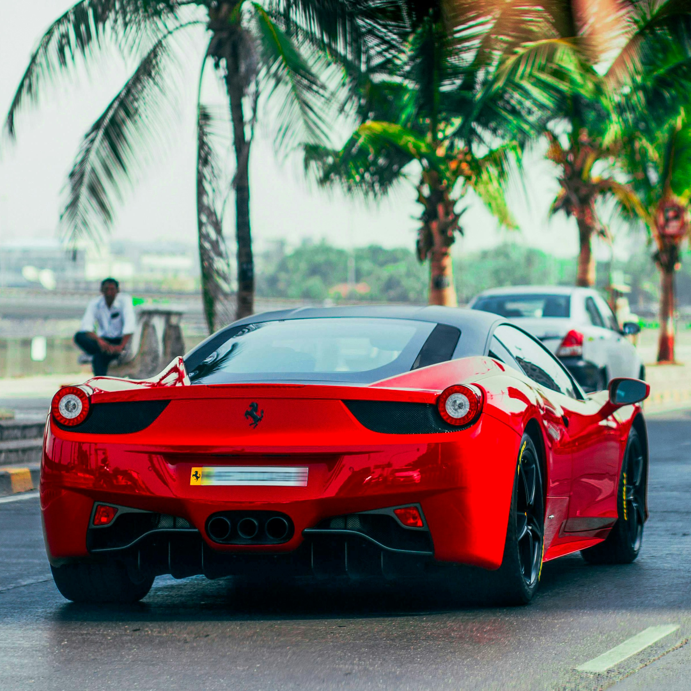 A red sports car driving down a street photo – Free Sports car Image on ...