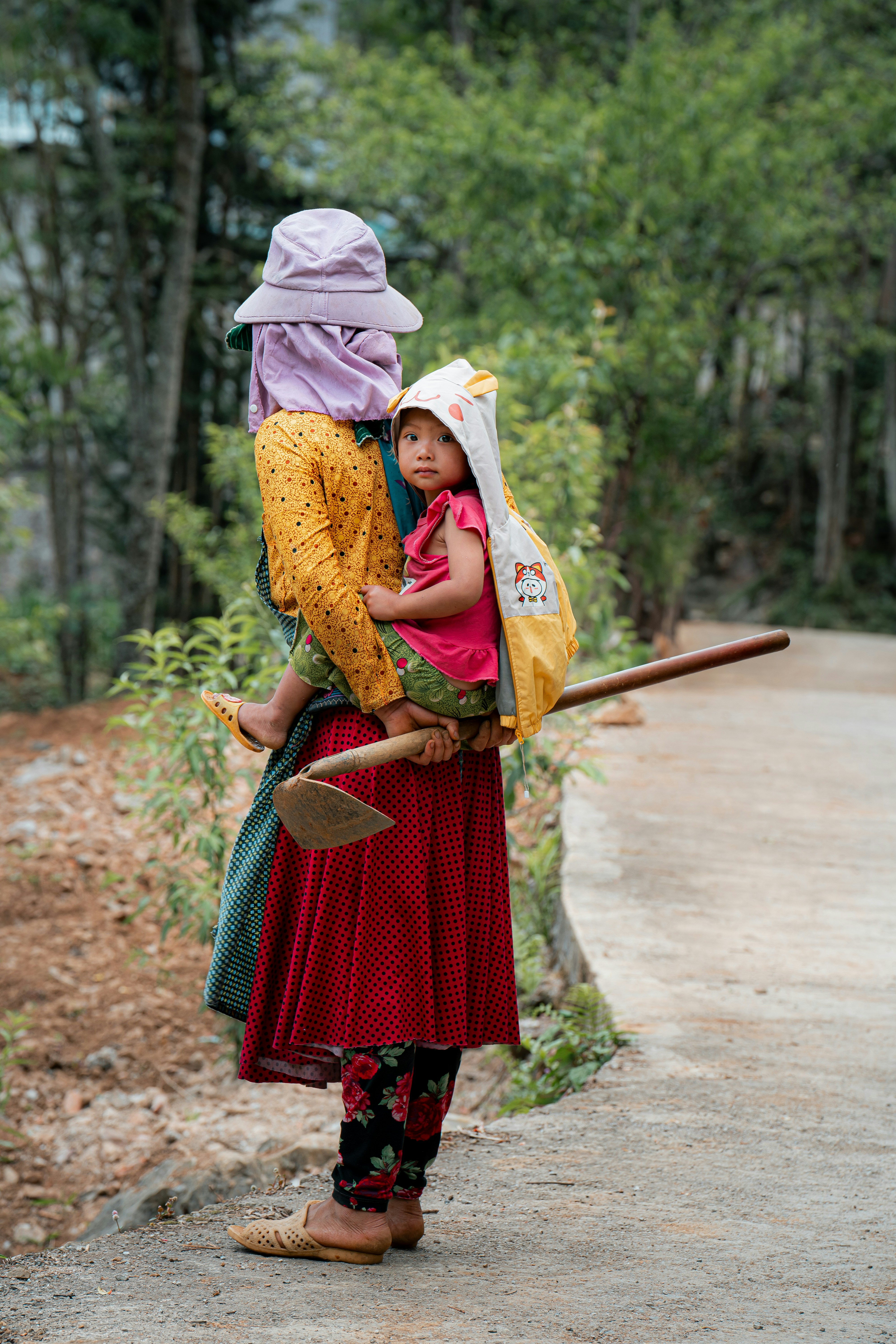 A woman carrying a child on her back photo – Free People Image on Unsplash