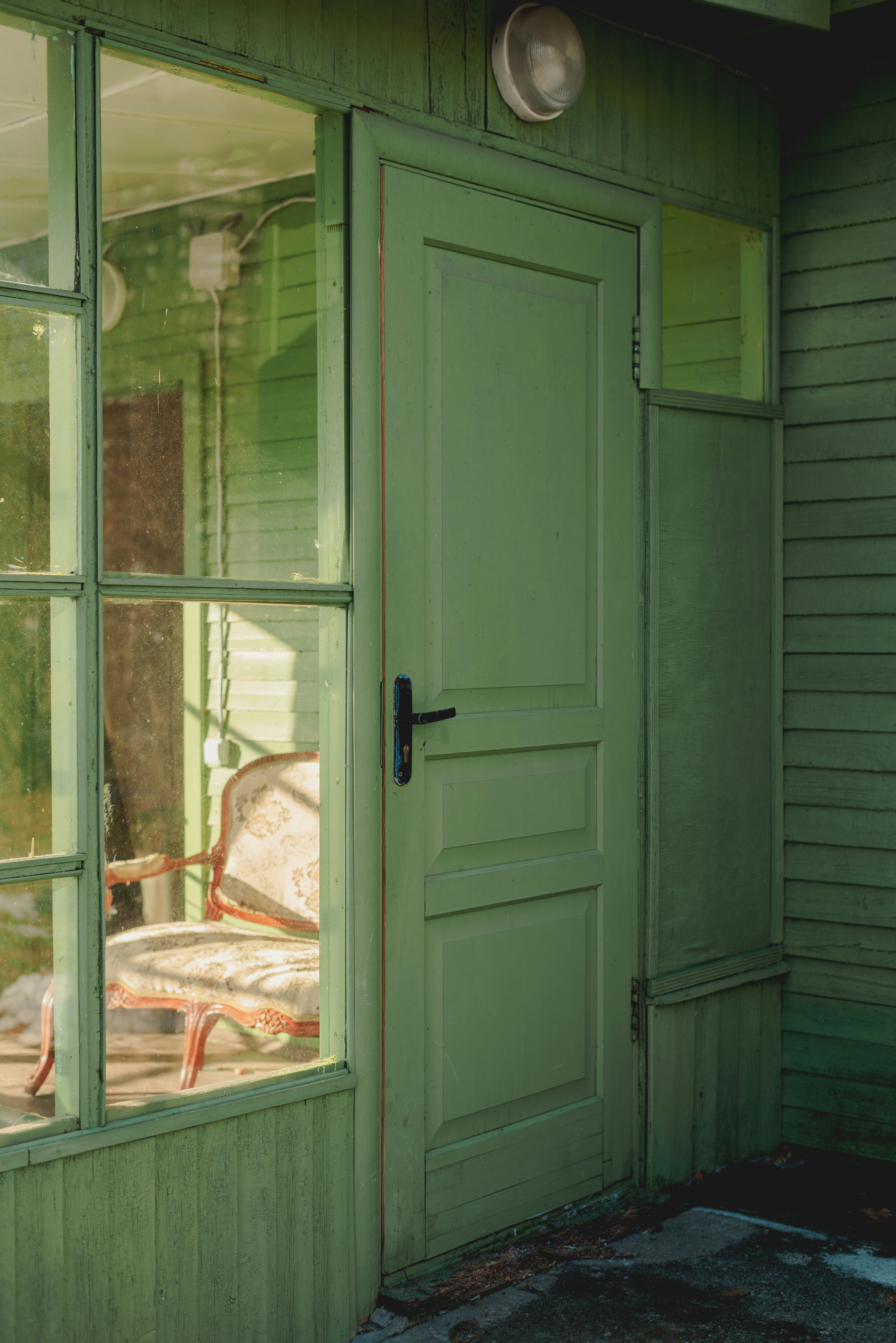 Emerald Threshold: A Weathered Green Door on a Quiet Porch