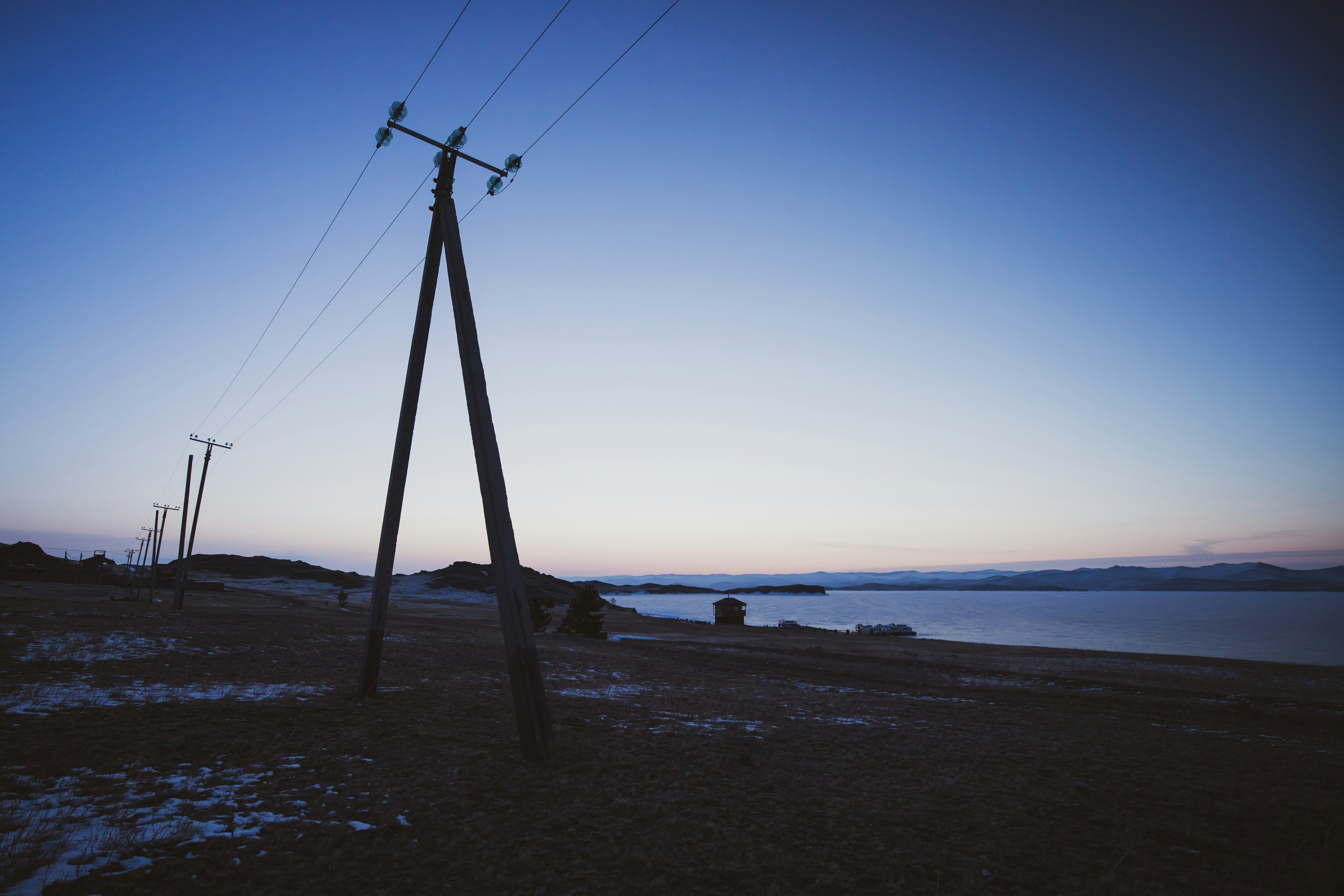 A telephone pole sitting next to a body of water photo – Free Lake ...
