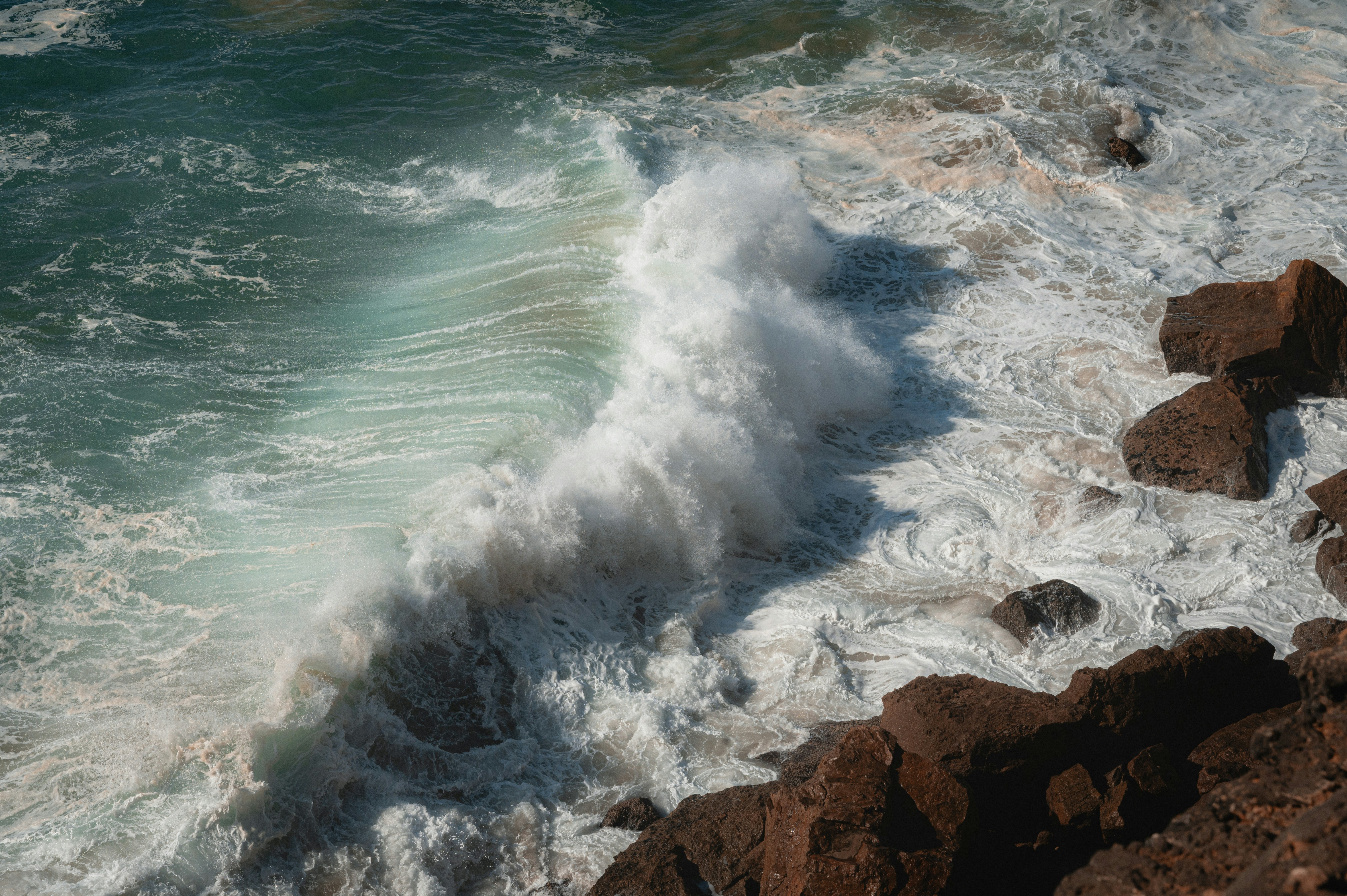 A wave crashes into the rocks at the beach photo – Free Tonel Image on ...