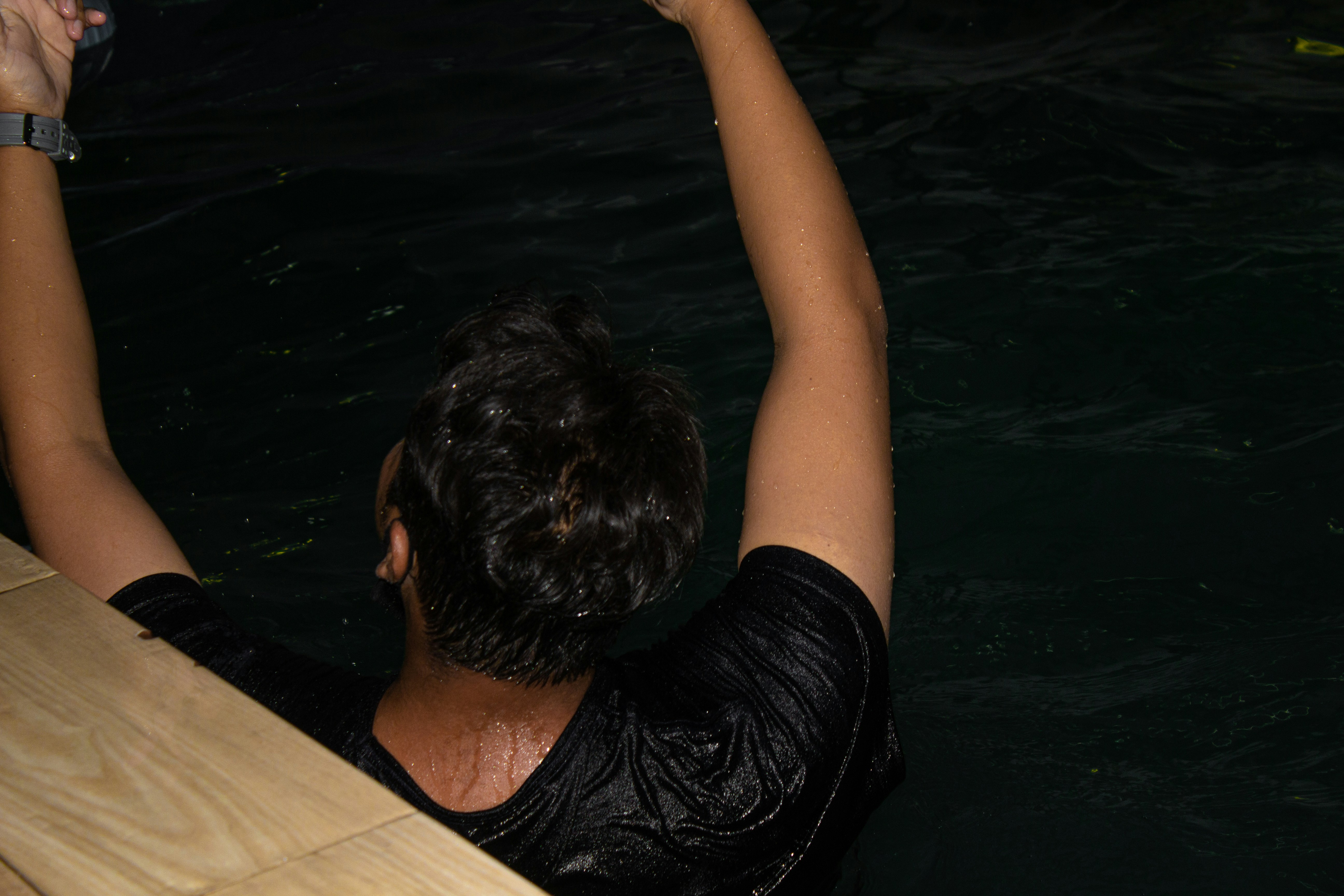 Midnight Silhouette at the Dock: Arm-Raised Figure Over Quiet Water